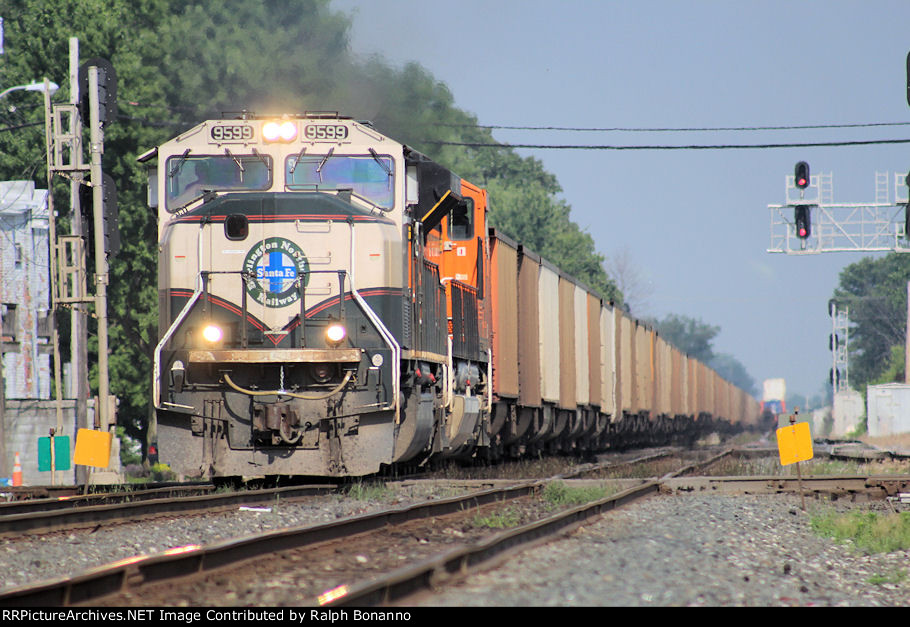 BNSF green and cream leads a westbound empty hopper train into the afternoon sun