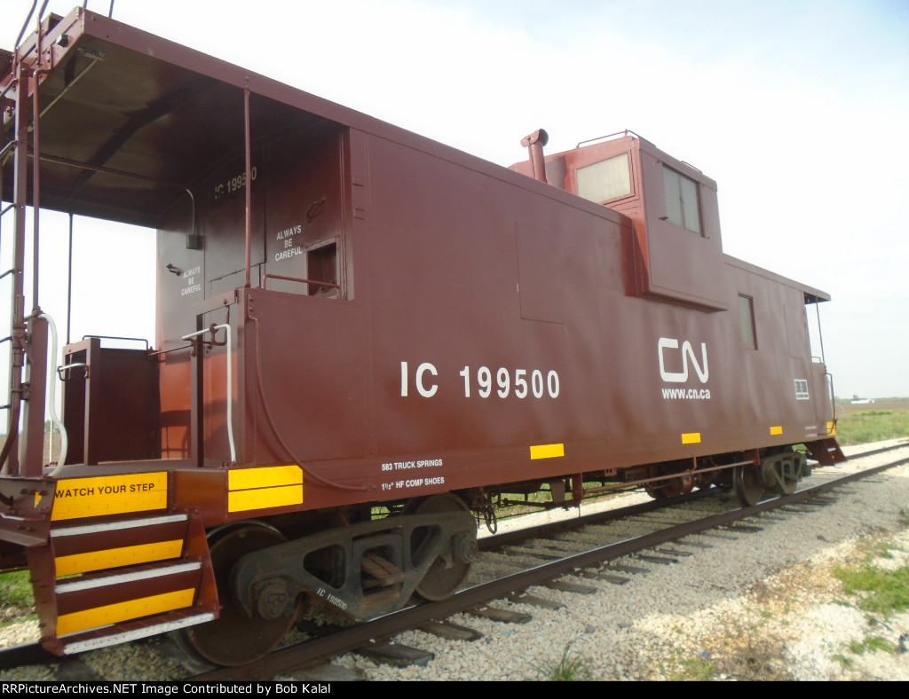 a string of hoppers sitting `n the west side of CR 900 E with IC 199500 CN Caboose on the end