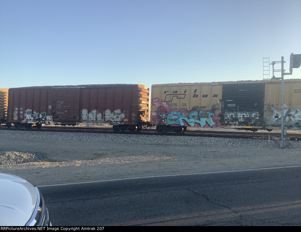 A Maroon Union Pacific Boxcar (BKTY) and a Railbox (RBOX) Head South at Niland