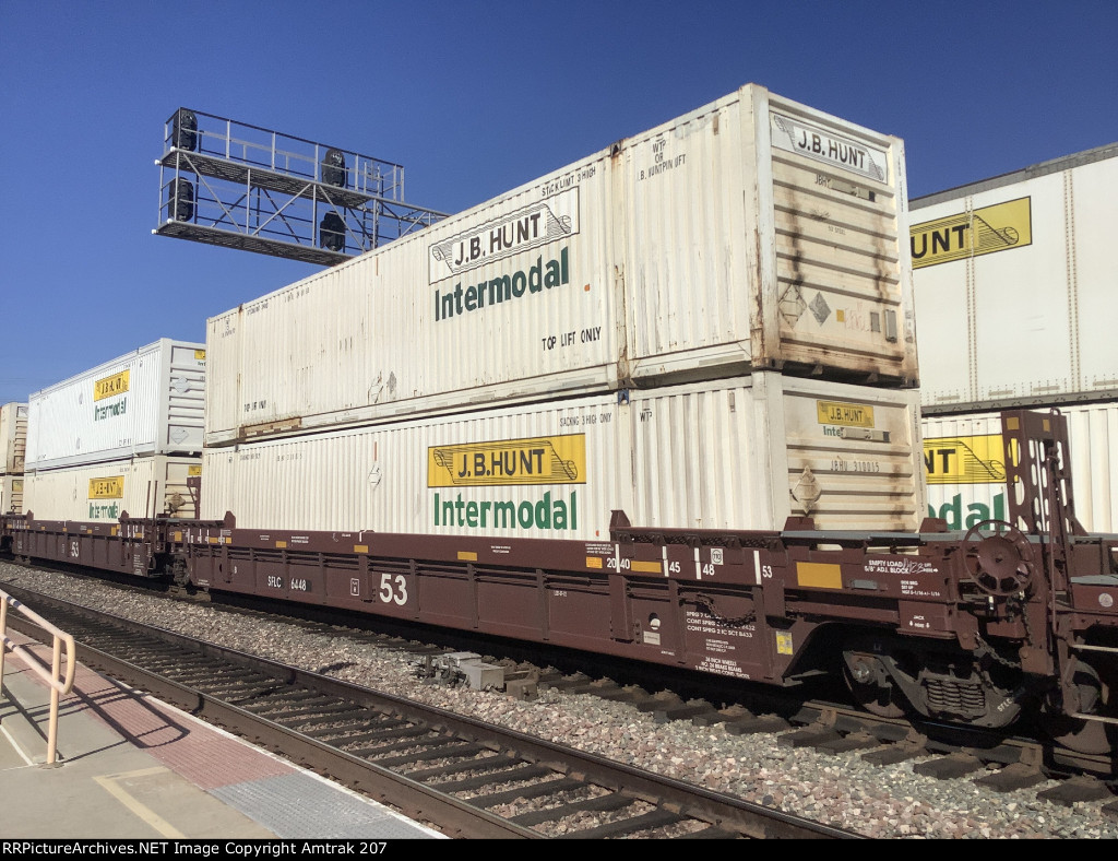 A Maroon BNSF Well Car Passes Commerce