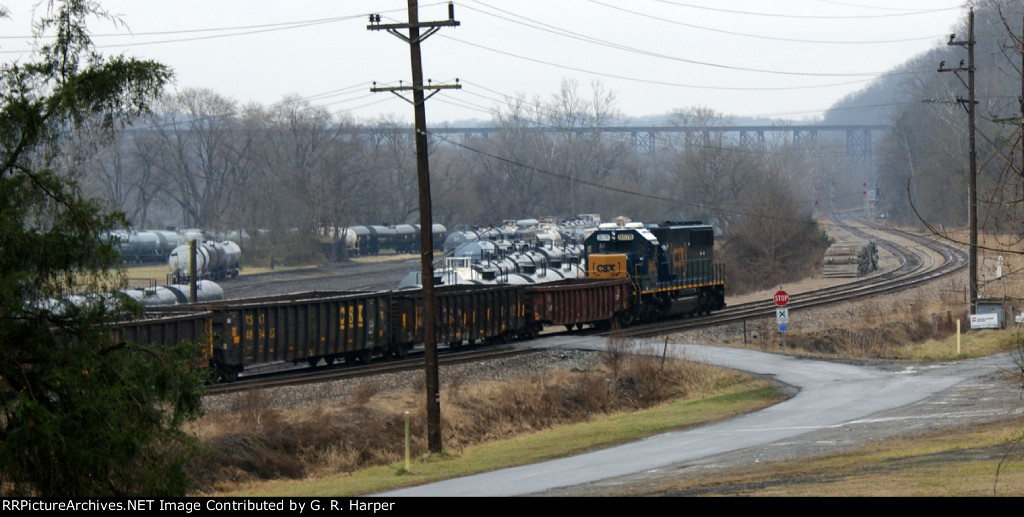 CSX 8578 eases a work train down the siding to pick up that pile of concrete ties that's been ...