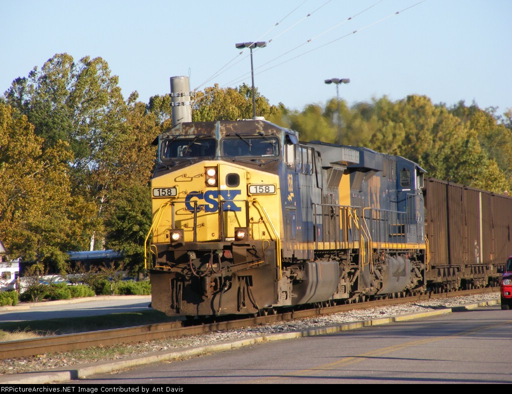 A battered and weathered CSX 158 leads an empty coal train out of town