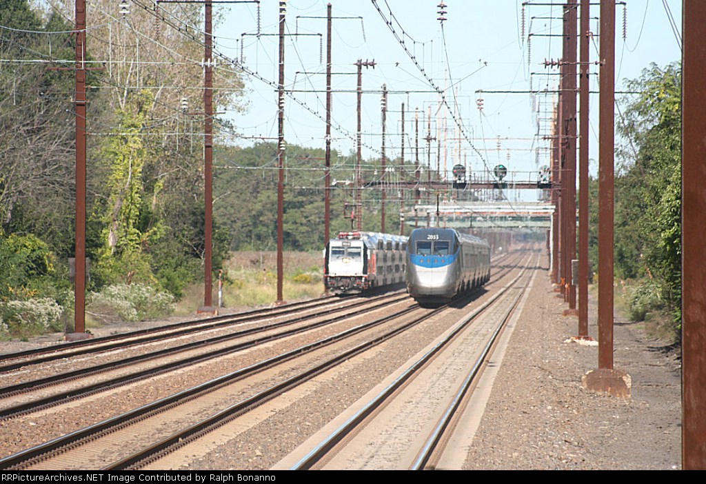Northbound ACELA passes a southbound Trenton-bound NJT local just north of the station.