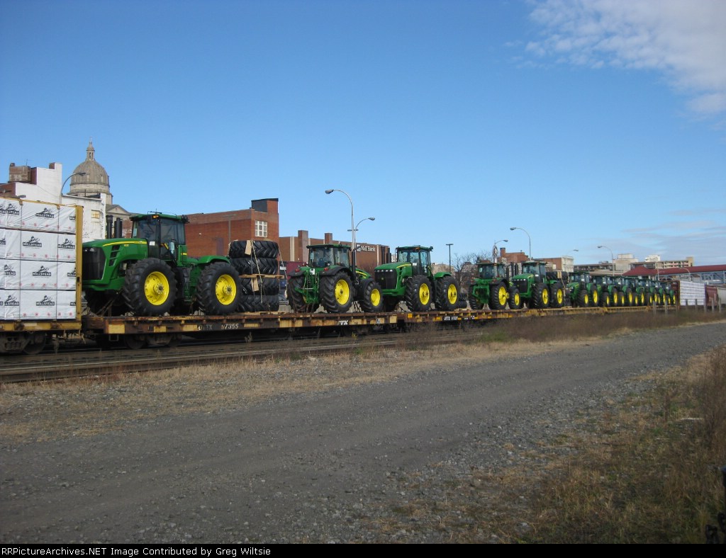 A string of 5 OTTX flatcars with John Deere tractors head into Altoona and Rose Yard