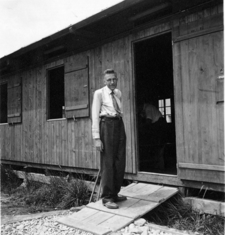 An Unidentified Man Stands in Front of a Wooden Building | Harry S. Truman