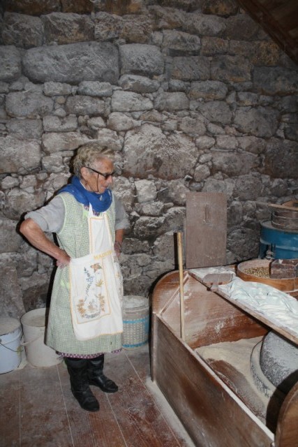 Oud vrouwtje die mais maalde tot meel | Foto | Duitsland en Oostenrijk 2024