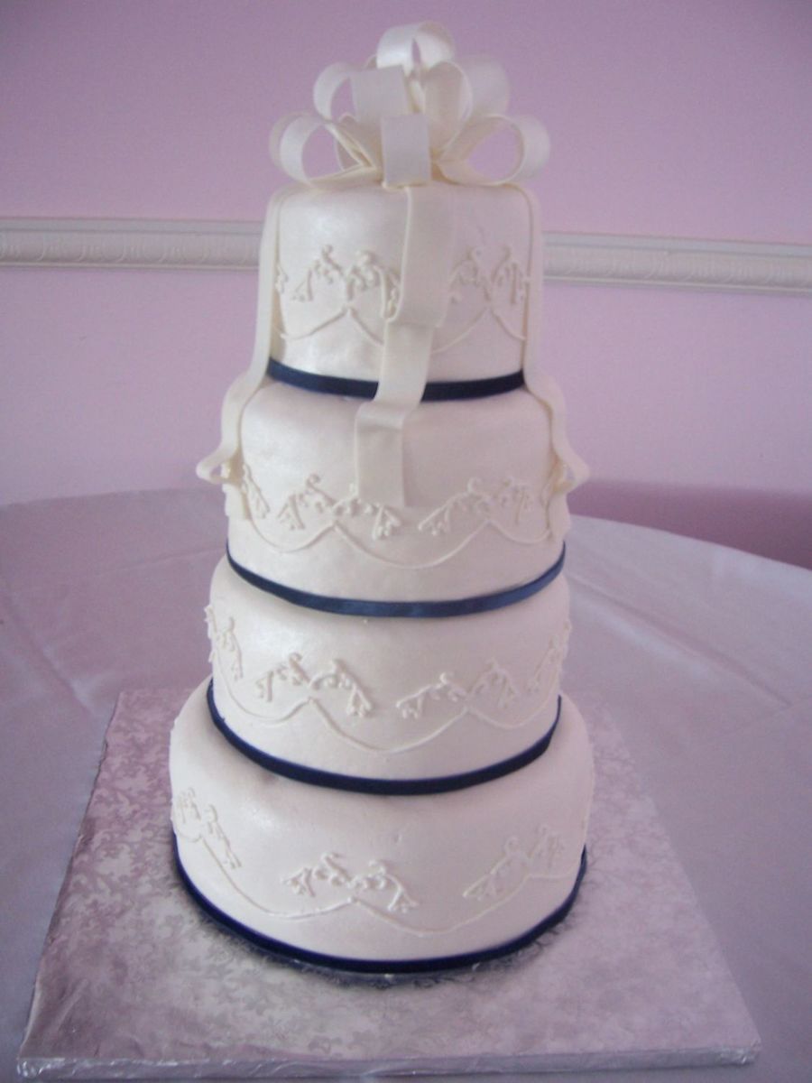 White Wedding Cake With Ribbon And White Royal Icing Lace On Side ...