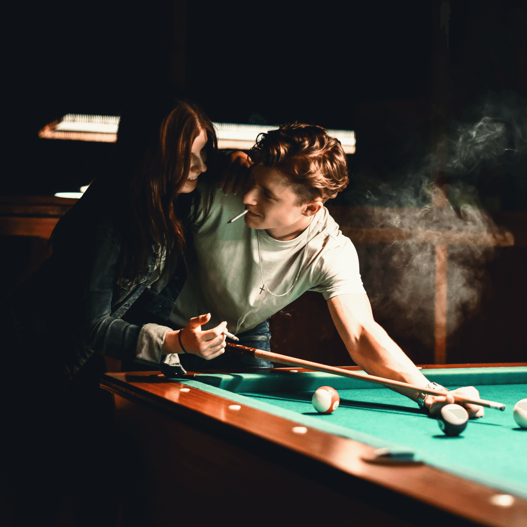 Couple Playing Pool In Bar Smoking
