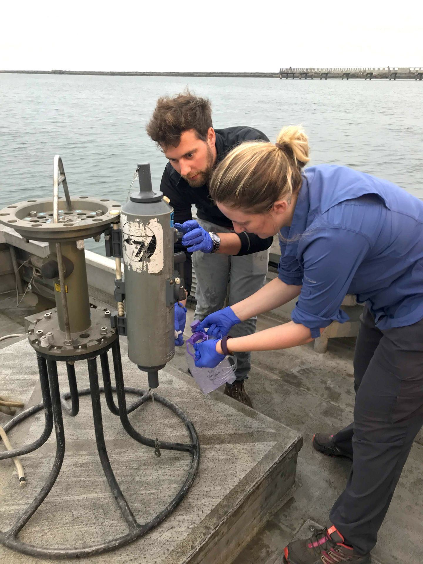 Photo | Adam Wall and Teia Schweizer with water sample tank on a boat ...