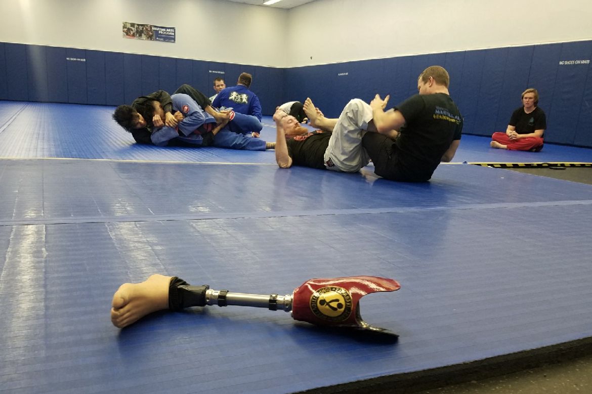 Photo | Three pairs of people training on mat in para-jiujitsu, with ...