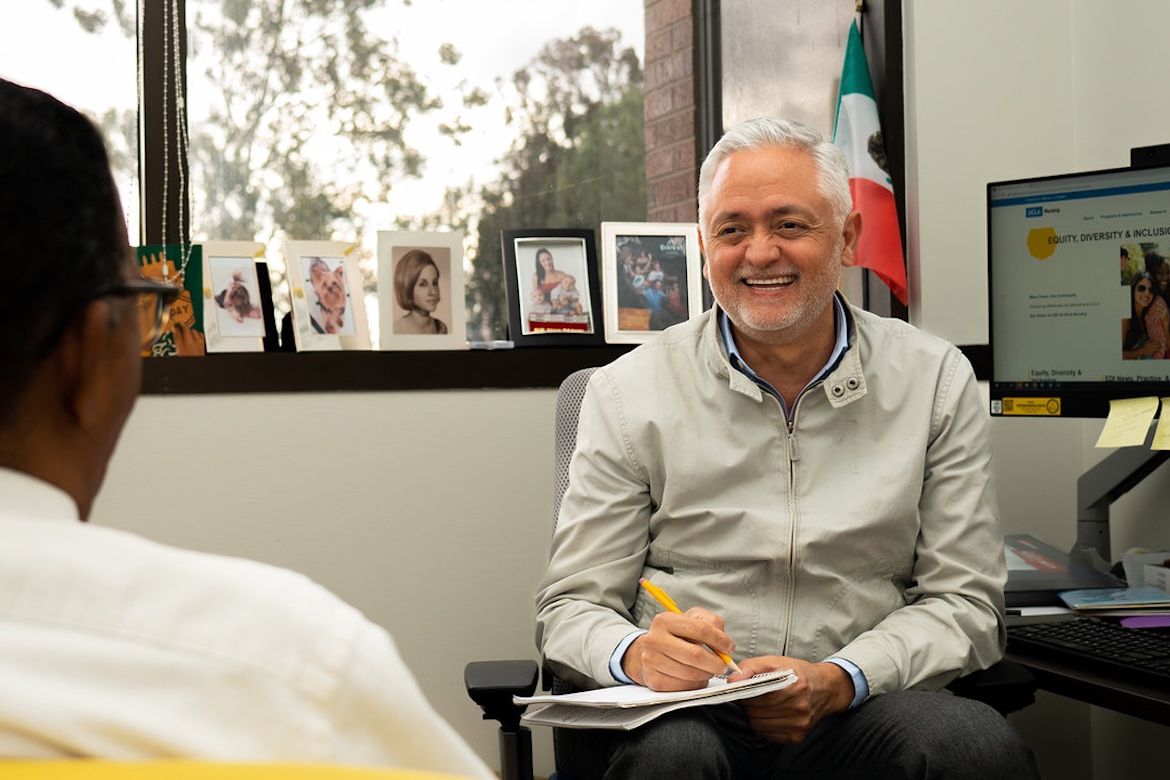 Photo | Robert Lucero speaking with colleague | UCLA