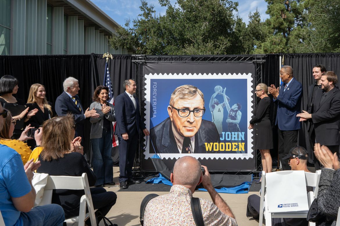 Photo | Group flanking enlarged John Wooden stamp at UCLA ceremony | UCLA