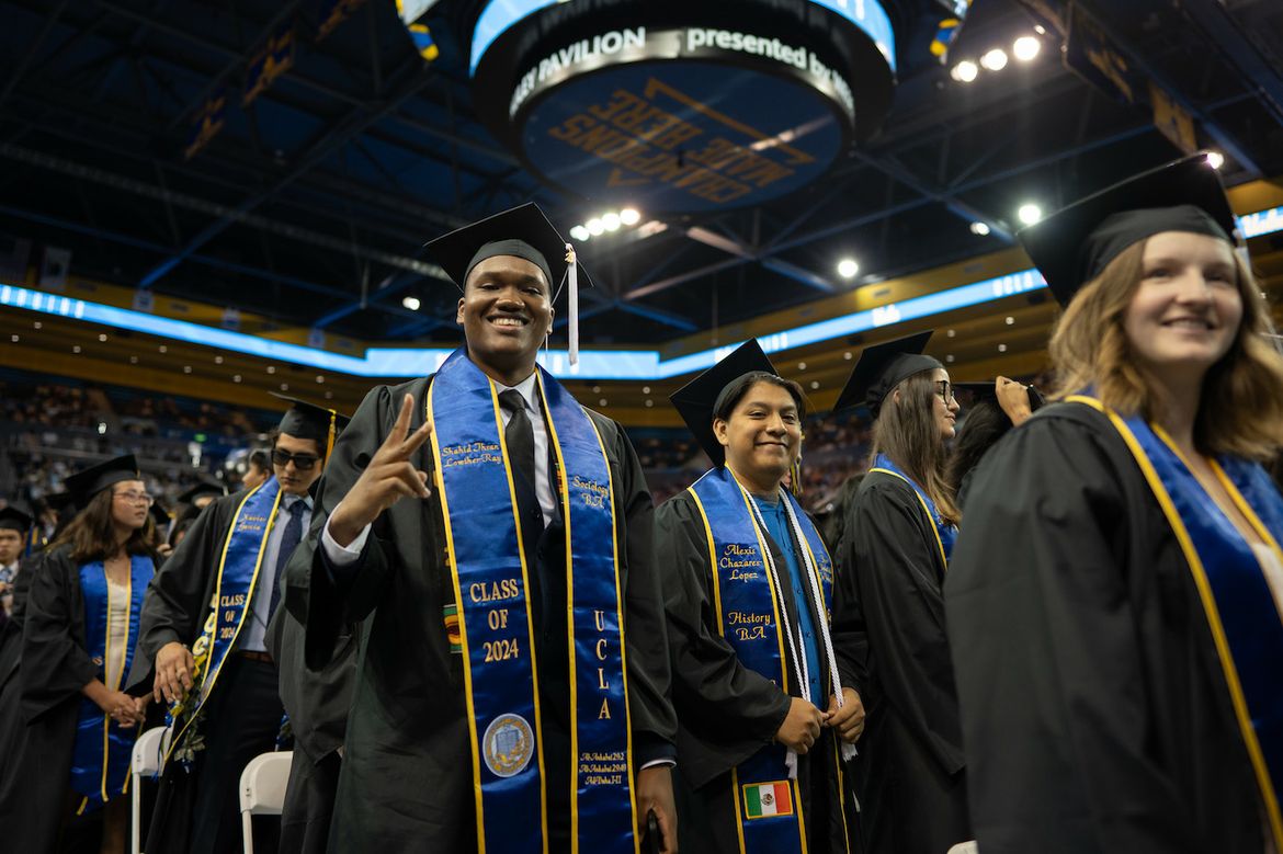 Photo | Student throws up peace sign while standing with fellow ...