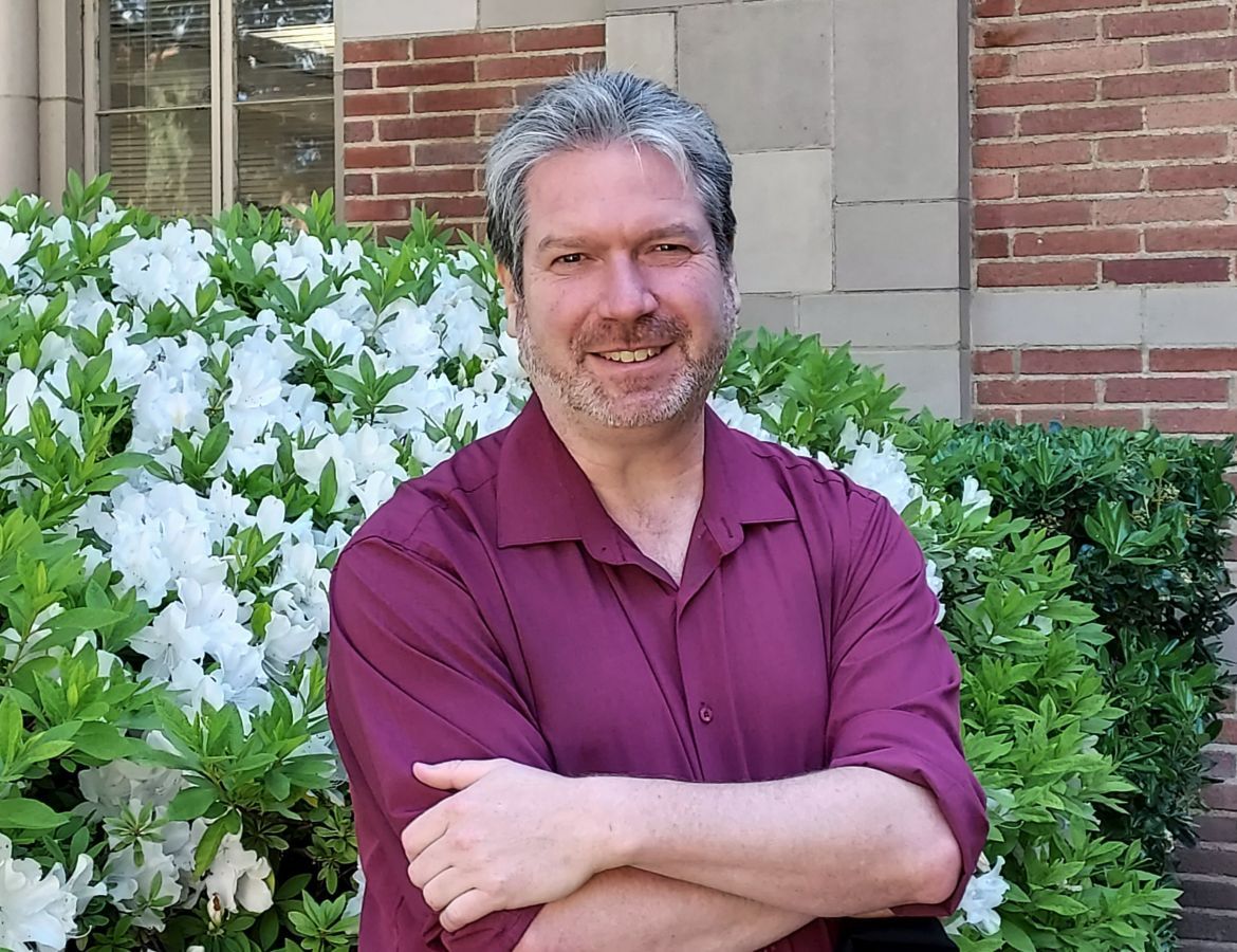 Photo | Michael Berry with arms crossed in front of red brick building ...