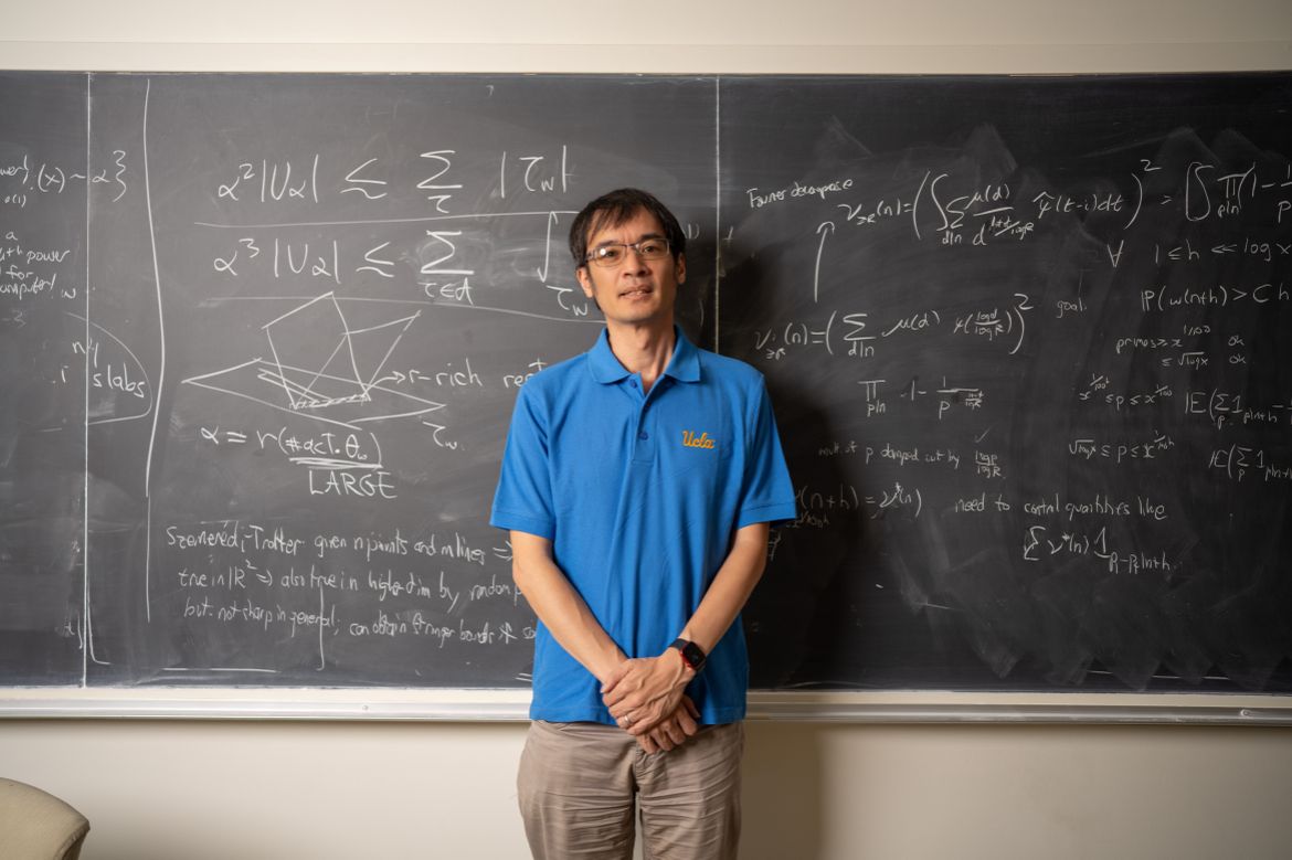 Photo | Terence Tao in front of chalk board with equations on it | UCLA