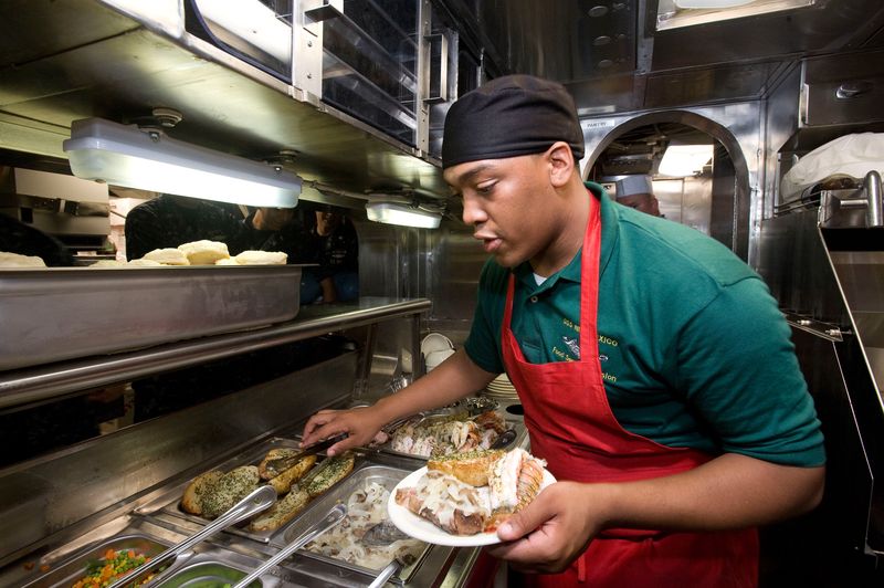 Photo | Seaman Mykal Martin helps serve the first meal on board the USS ...