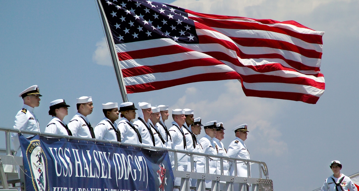 Photo | As the American flag flies in the background, sailors man the ...