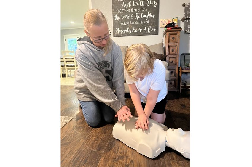 Photo | Woman showing child CPR technique | American Heart Association