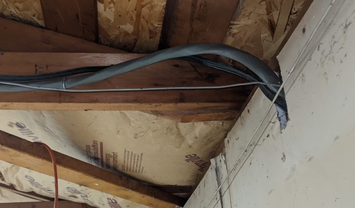 Electrical cables transition from finished wall to unfinished ceiling ...