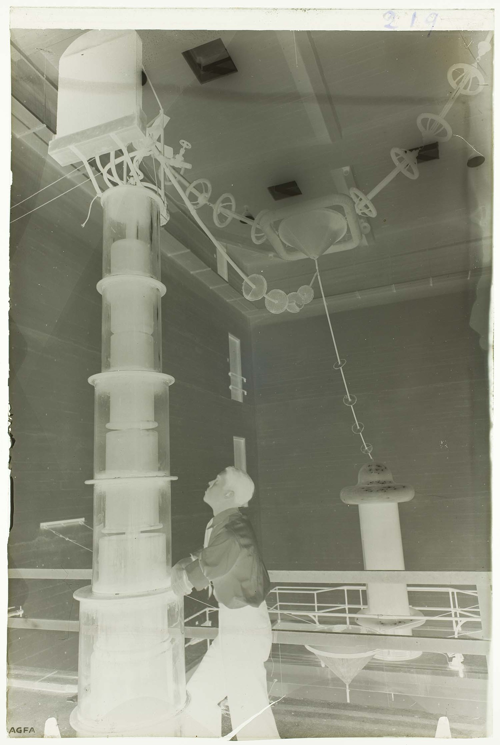 [Man looking at machine] | International Center of Photography