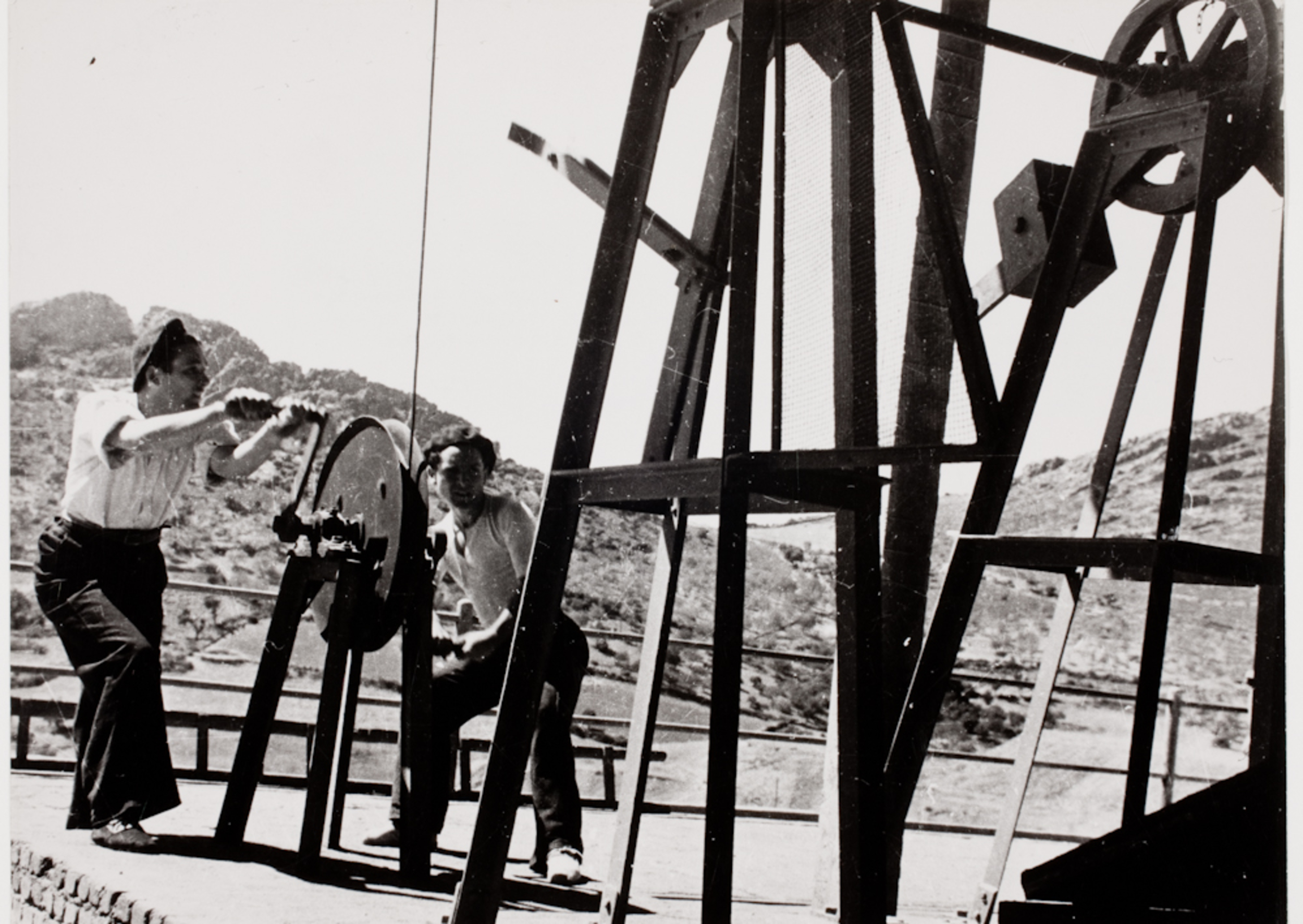 [Two miners operating the lift descending to the pit, Almaden, Spain ...