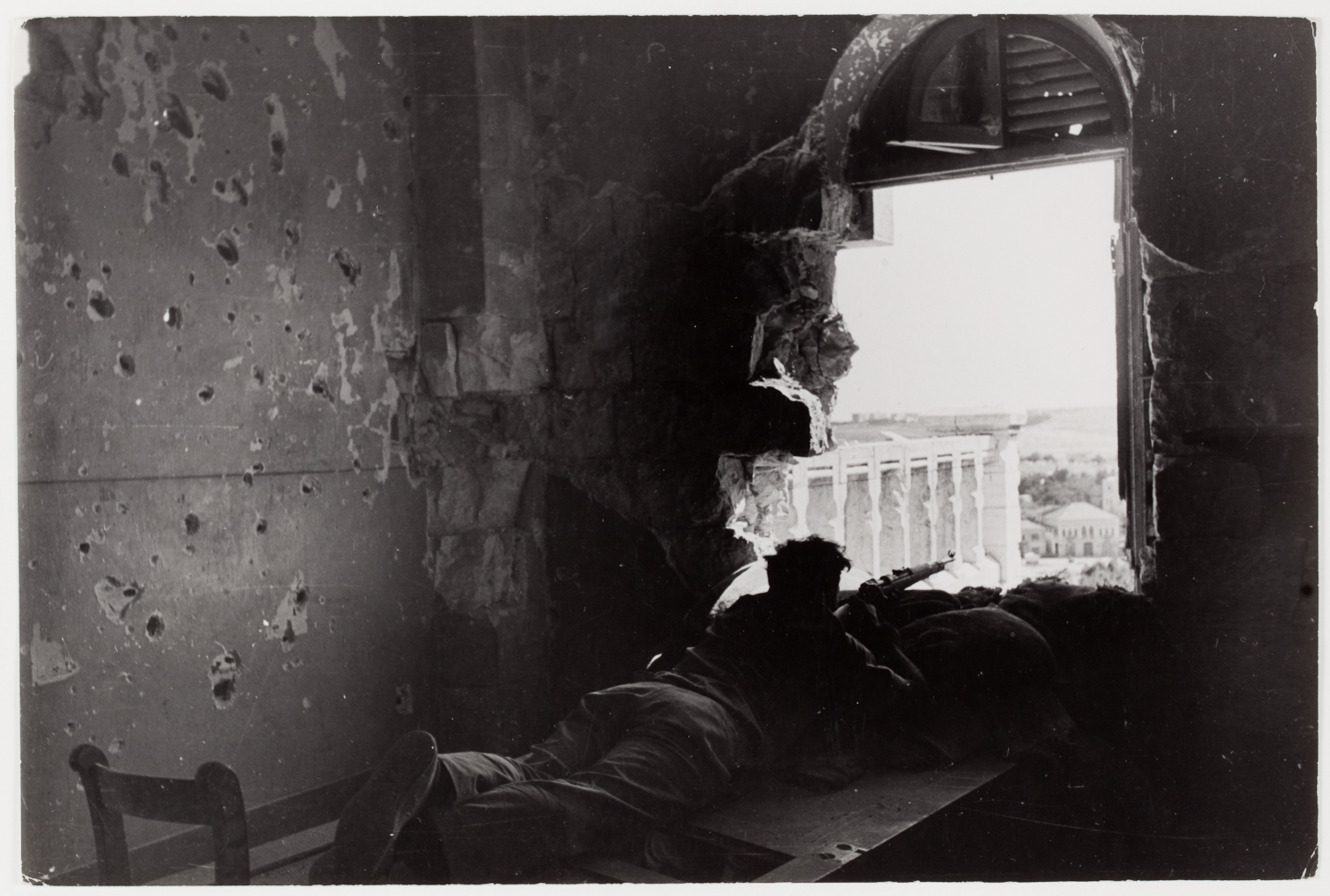 [Soldier with a gun looking out a window opening, Israel ...