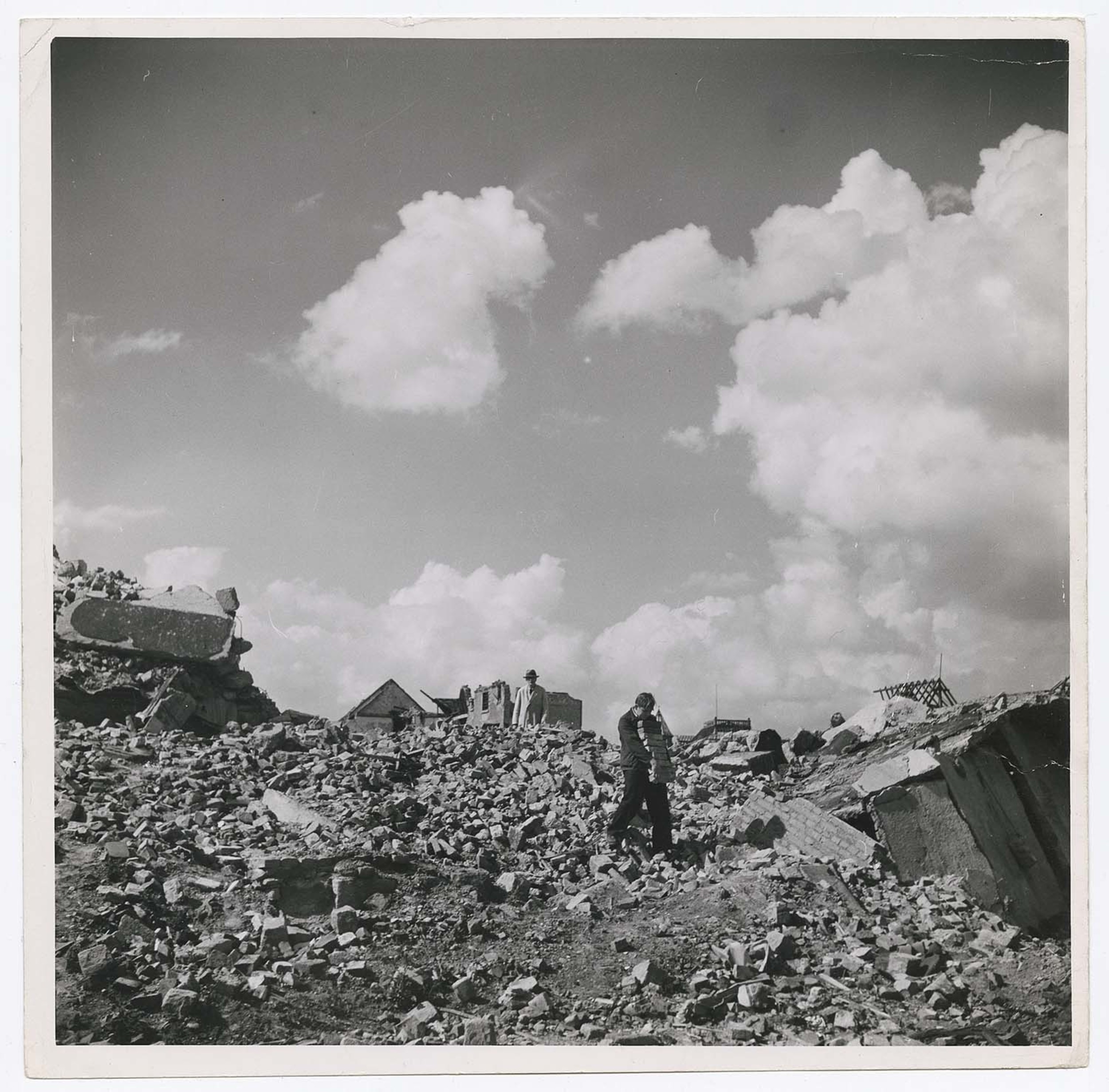 [People salvaging bricks and boards from bomb-damaged buildings of the ...