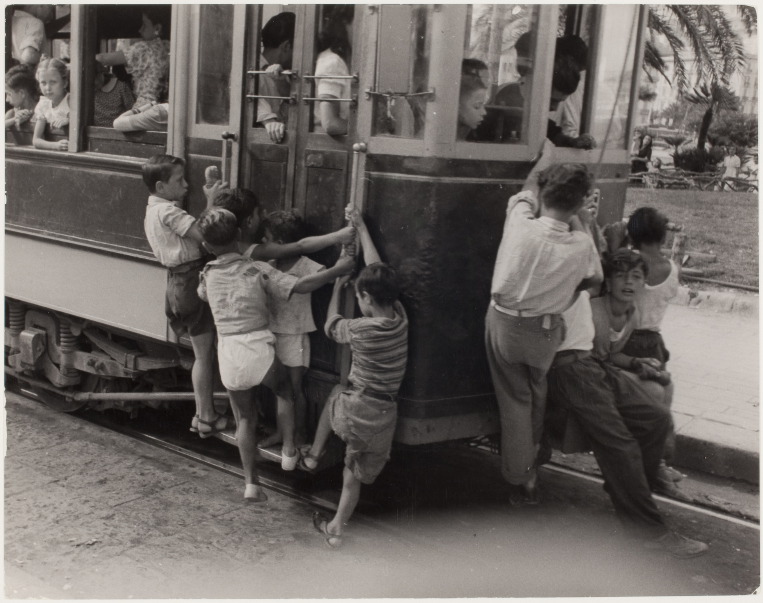 [Children hanging in the back of a tram, Naples] | International Center ...
