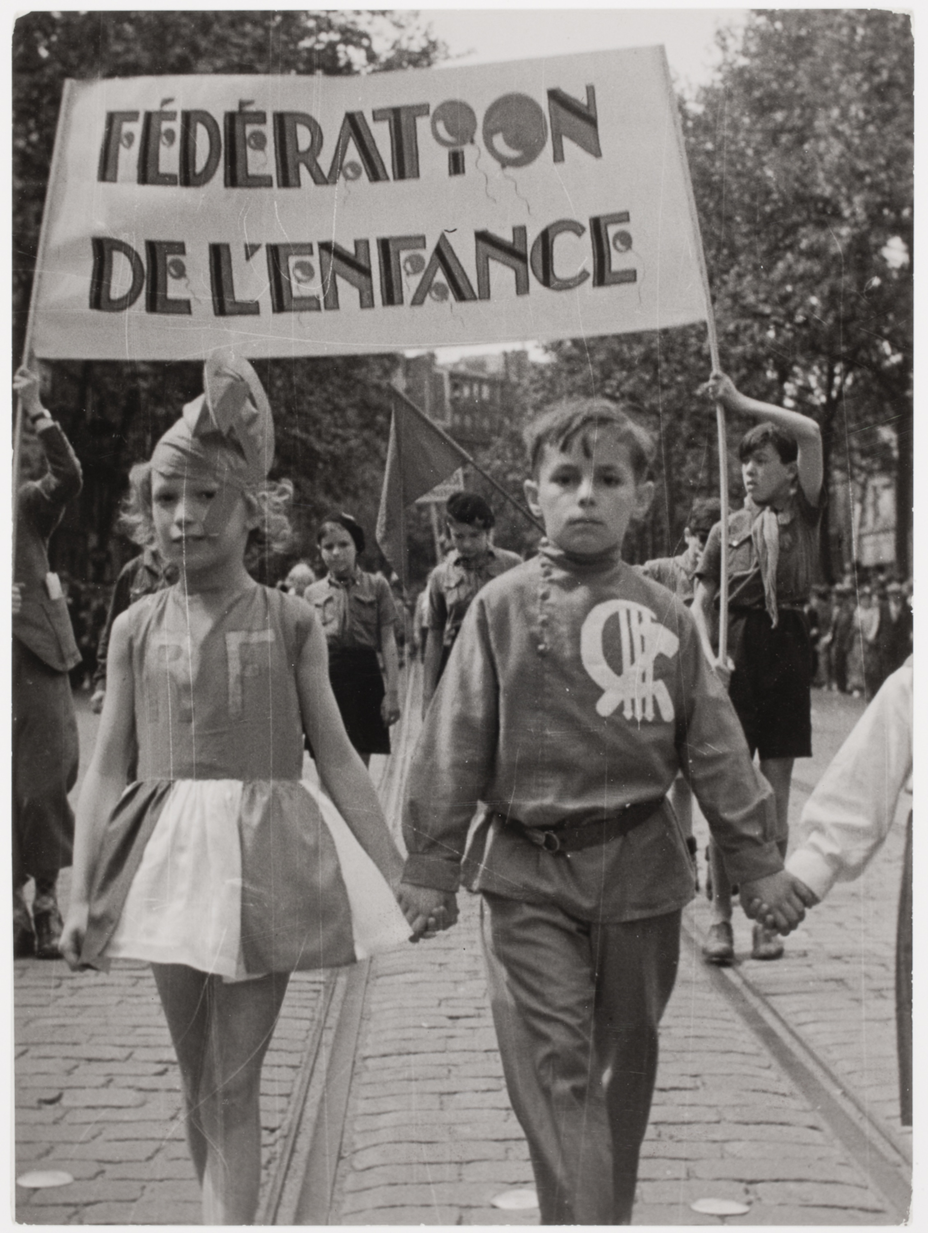[Children marching hand in hand in a demonstration wearing Communist ...