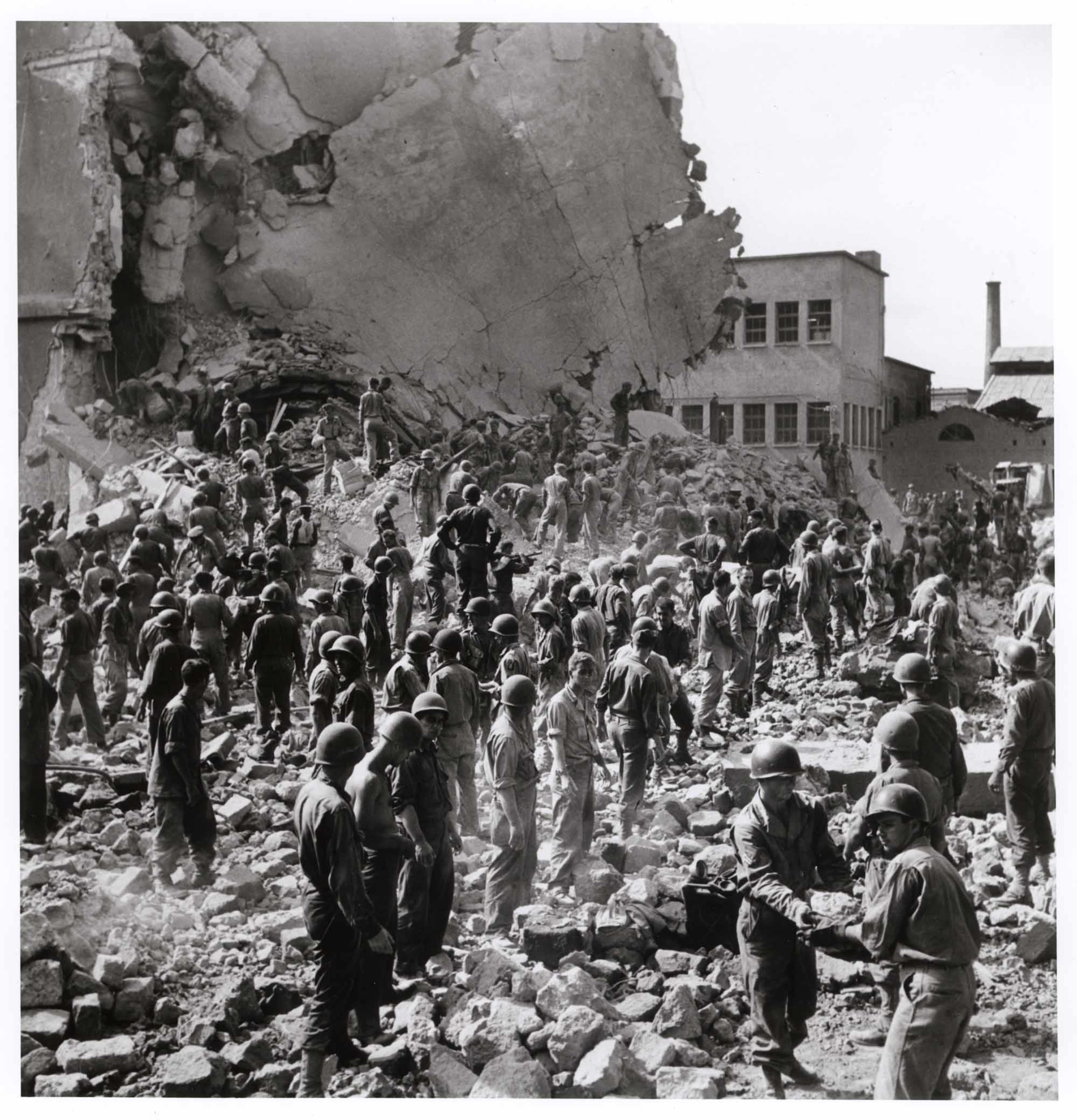 [Lines of people standing amid remains of the Central Post Office ...