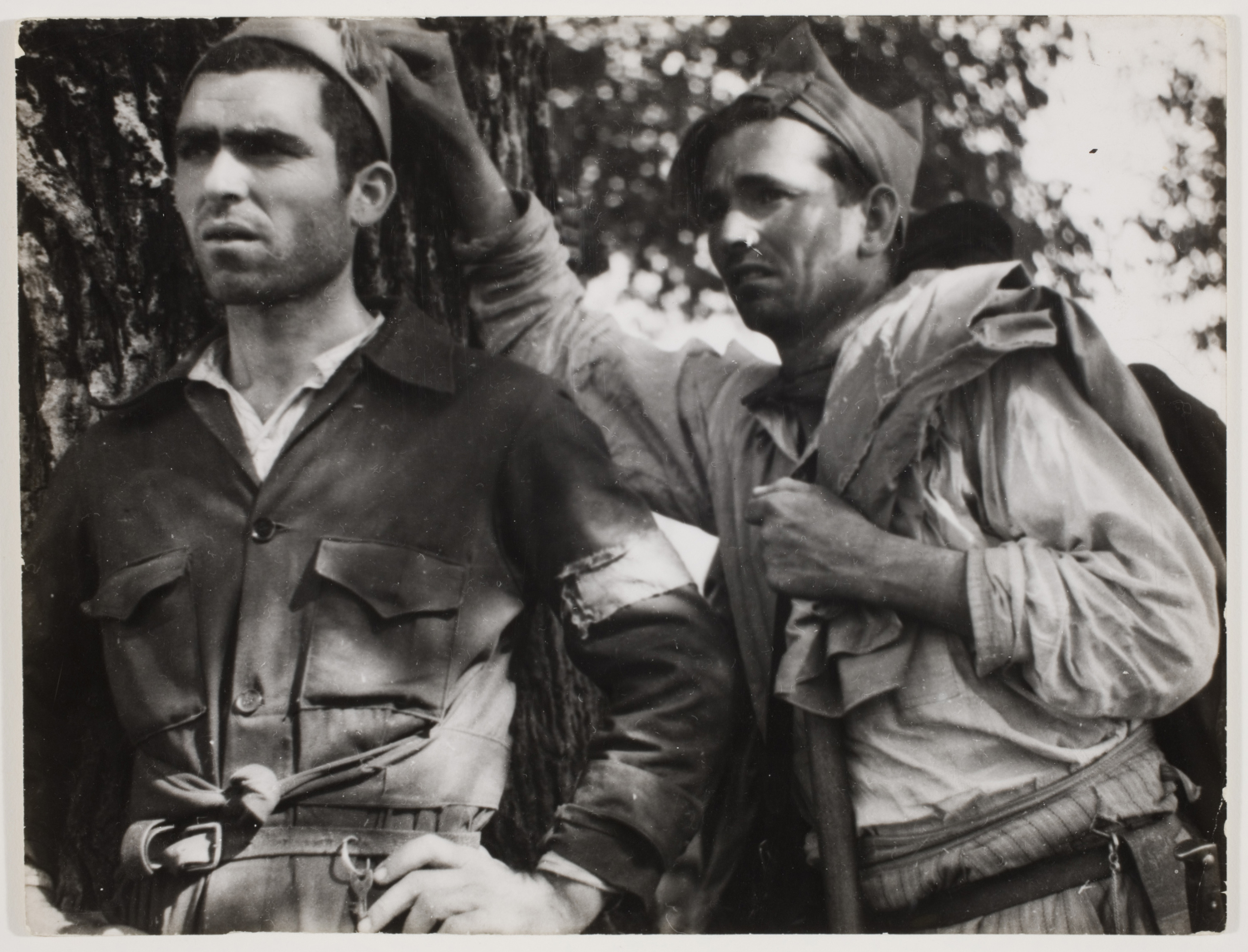 [Two loyalist soldiers leaning on a tree while listening to an officer ...