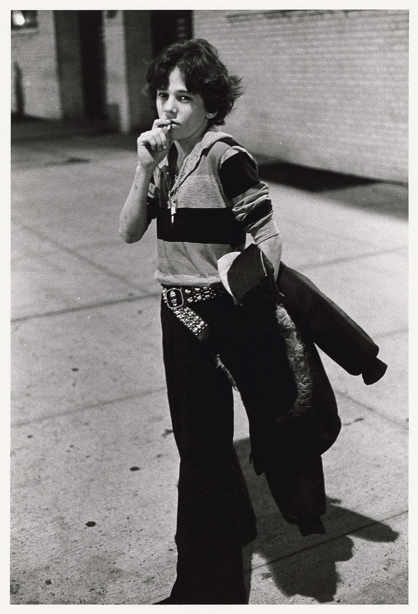 Young male street hustler, smoking, jacket on arm, New York City ...