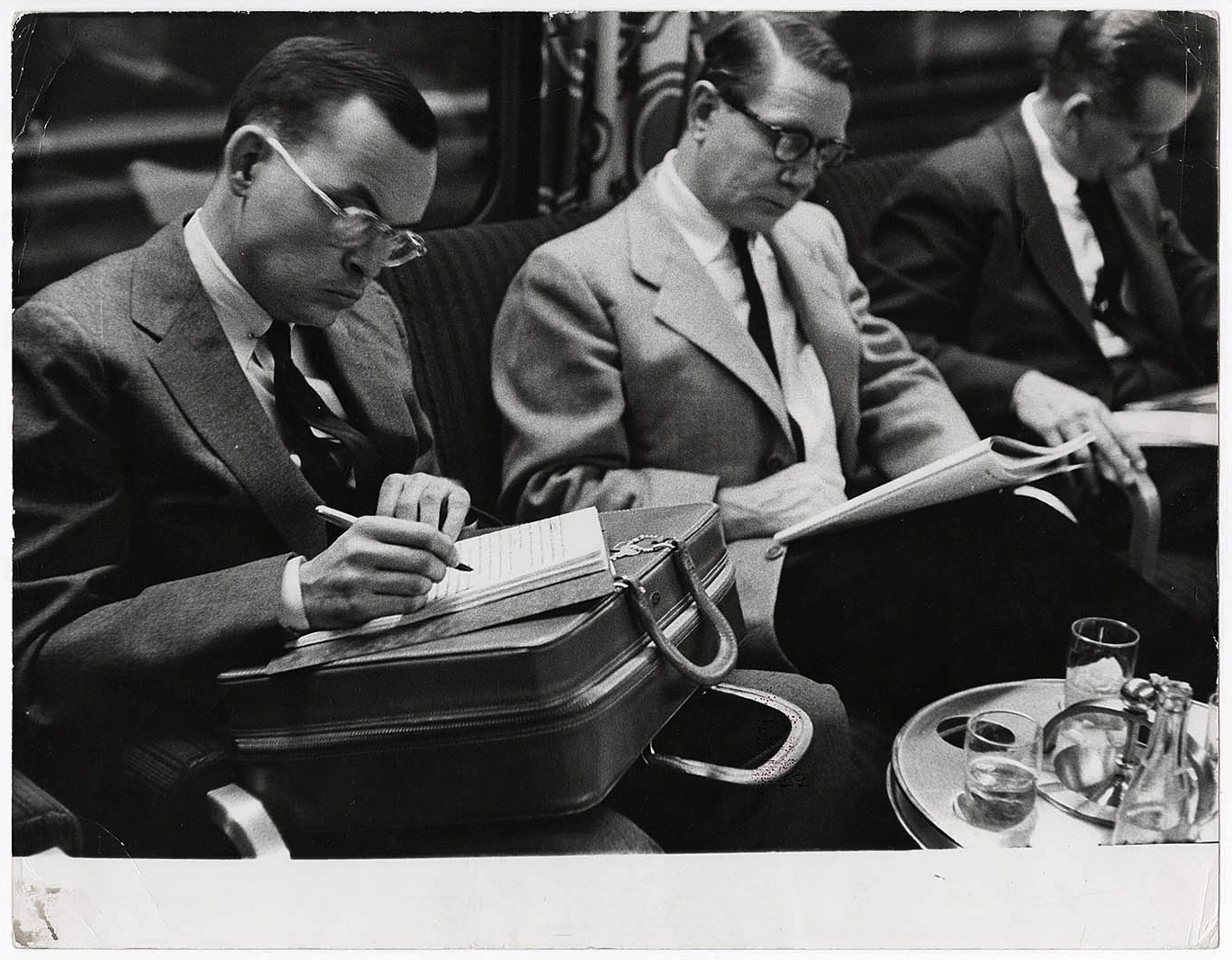 [Businessmen working on briefcases on laps during commute aboard ...