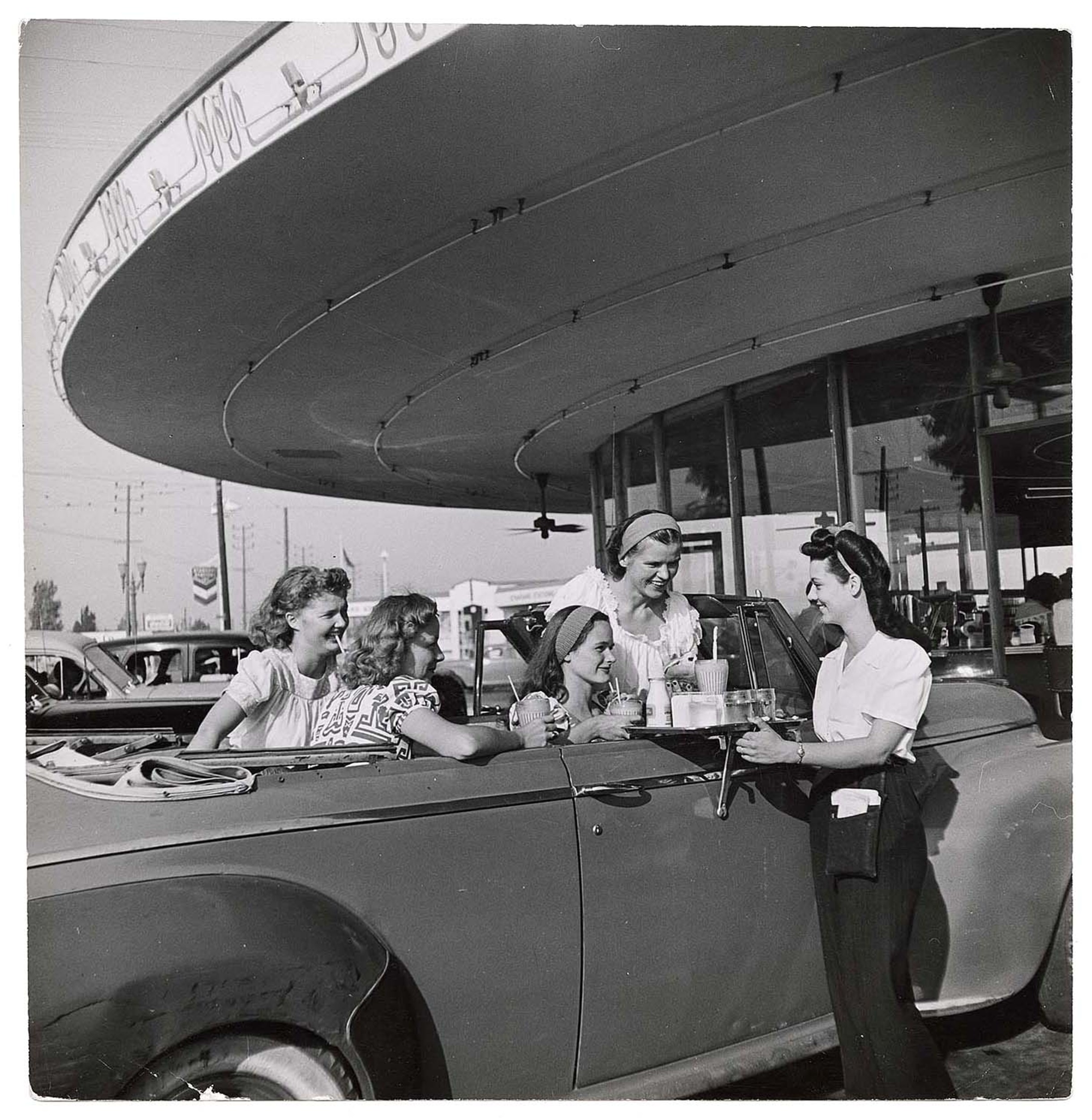 [Women and girls in convertible at a drive-in with car hop, California ...