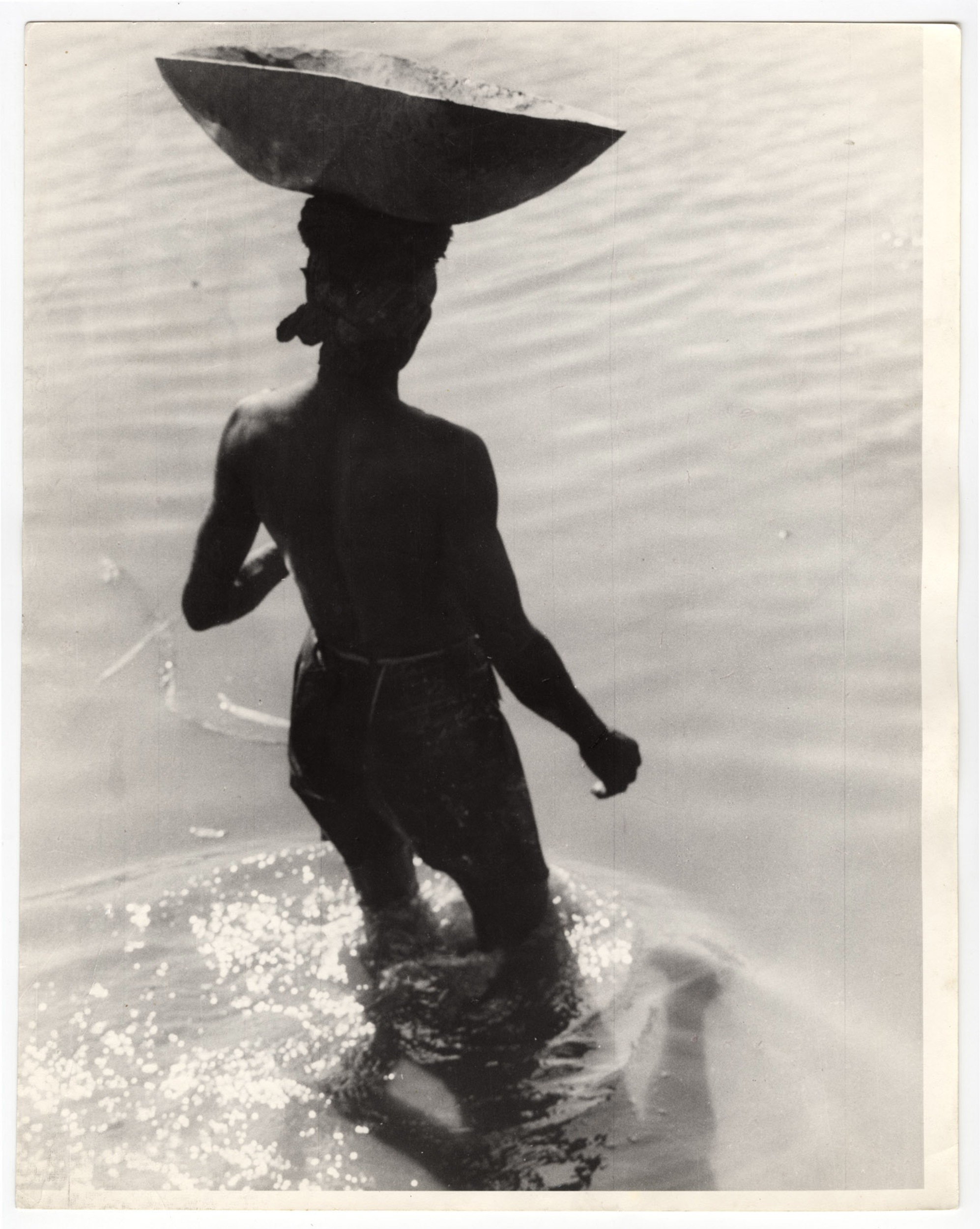 [Man wading in water with bowl balanced on head] | International Center ...