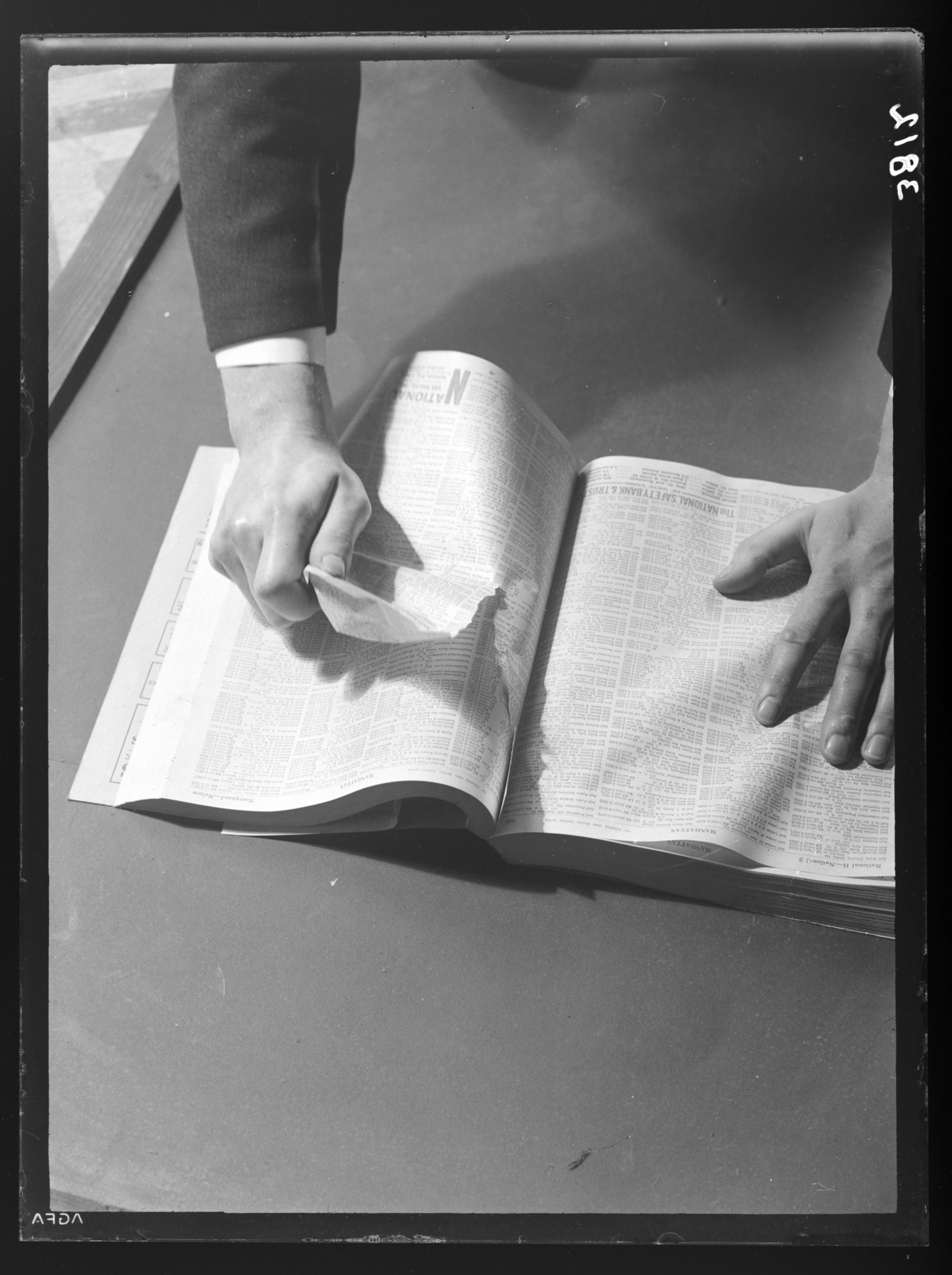 [Man ripping page from Manhattan telephone book] | International Center ...