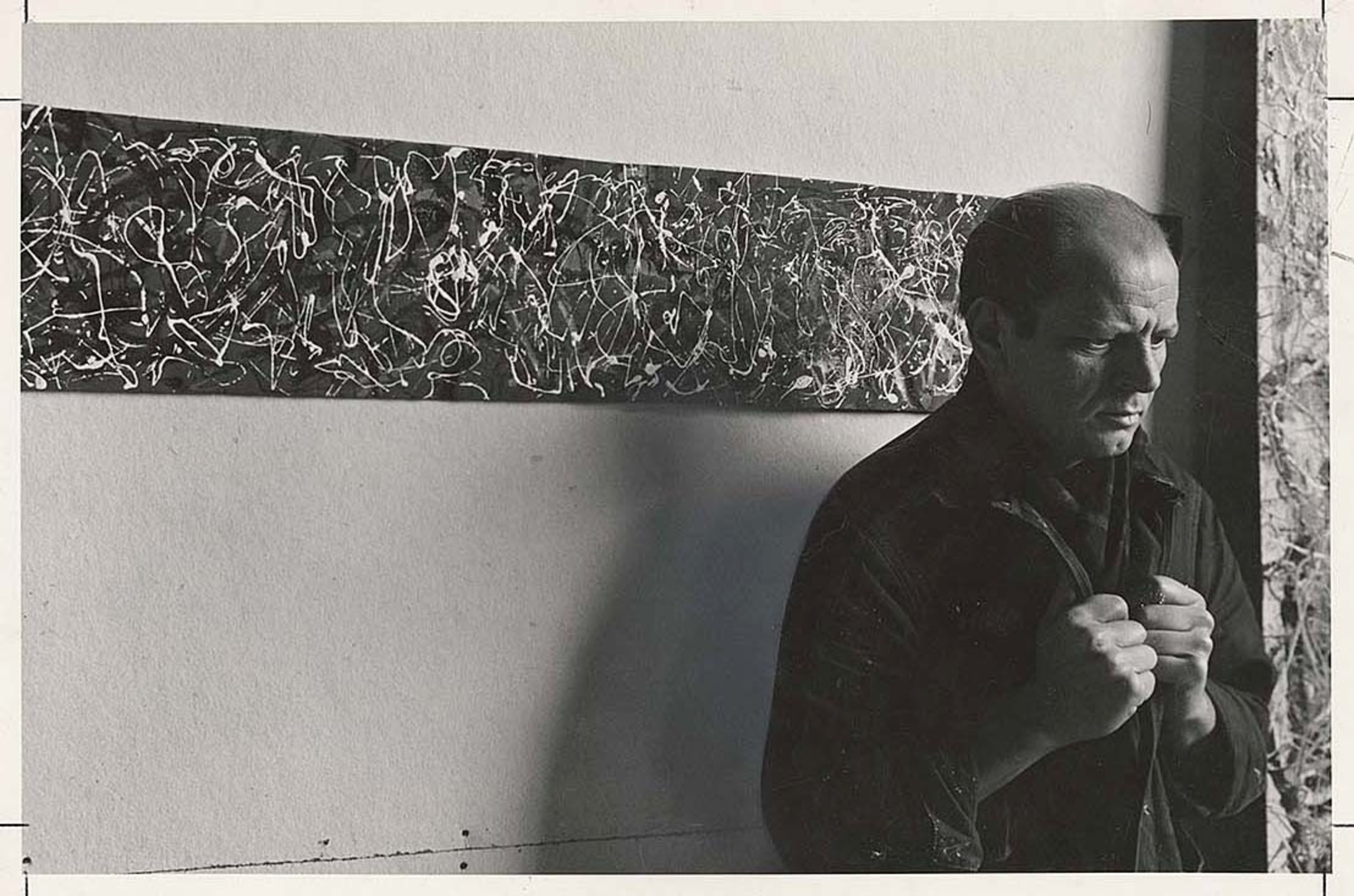 [Jackson Pollock standing in front of one of his paintings ...