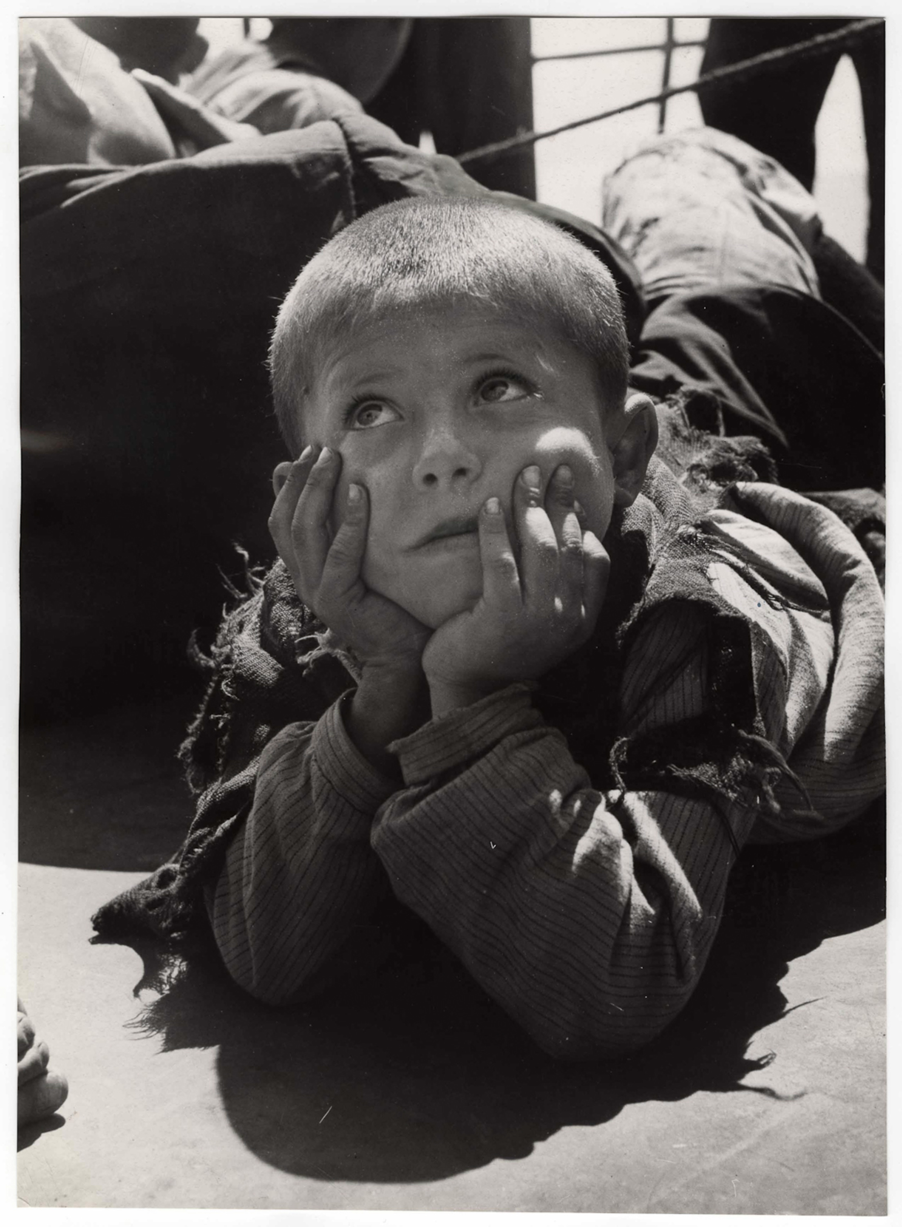 [Portrait of a child, hands supporting face, looking up ...