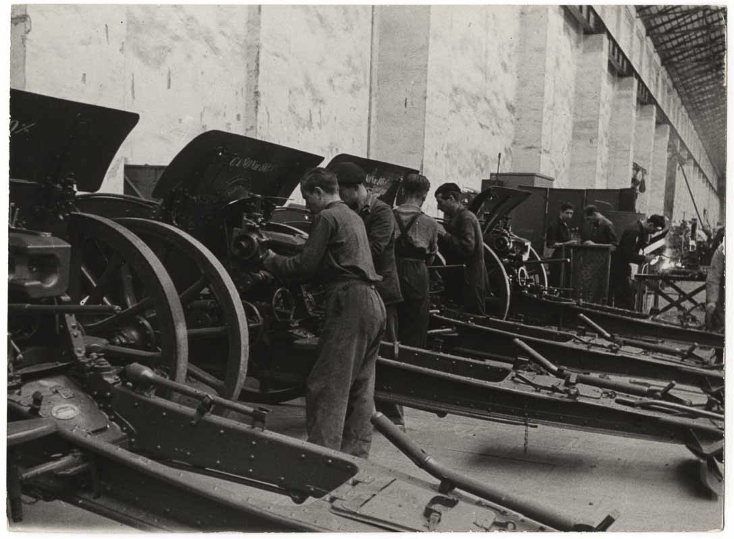 [Workers in row making cannons in a munitions factory, Spain ...