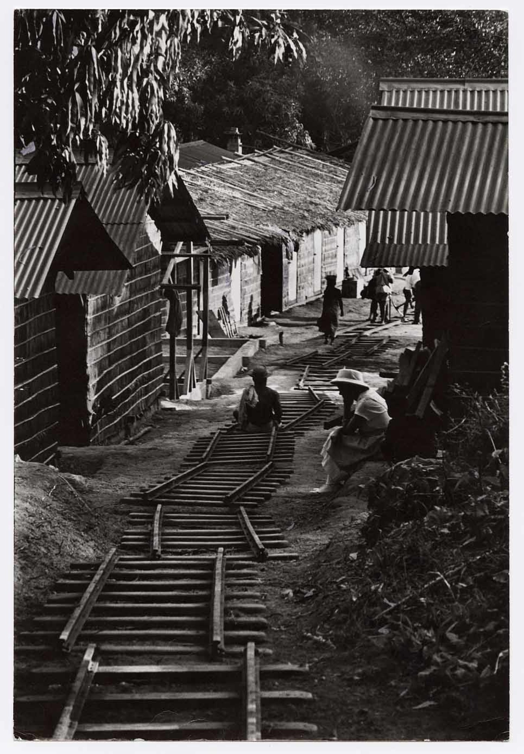 [Buildings and haphazardly aligned railroad track segments, people in ...