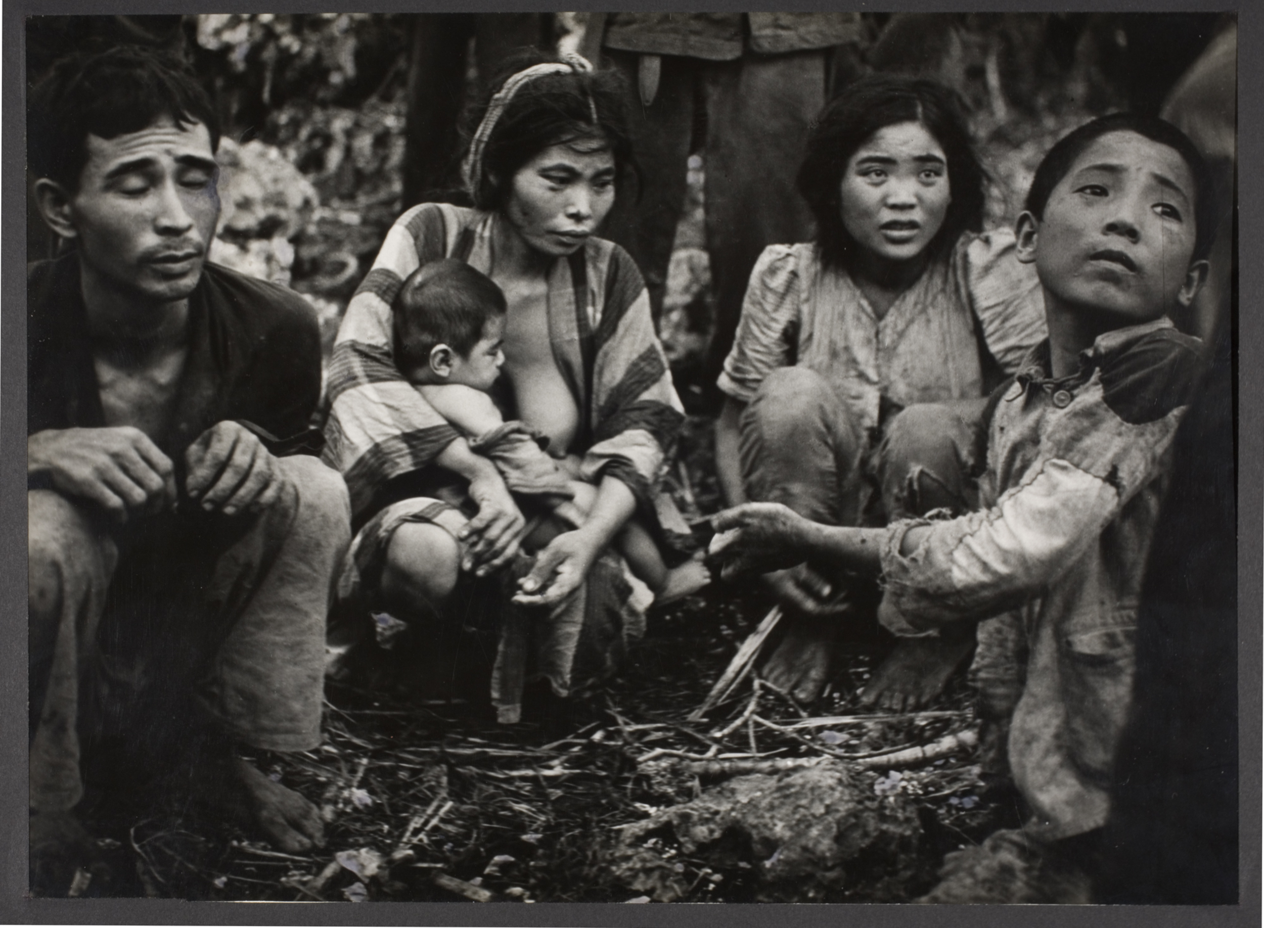 [Group of men, woman, and children crouching on ground] | International ...