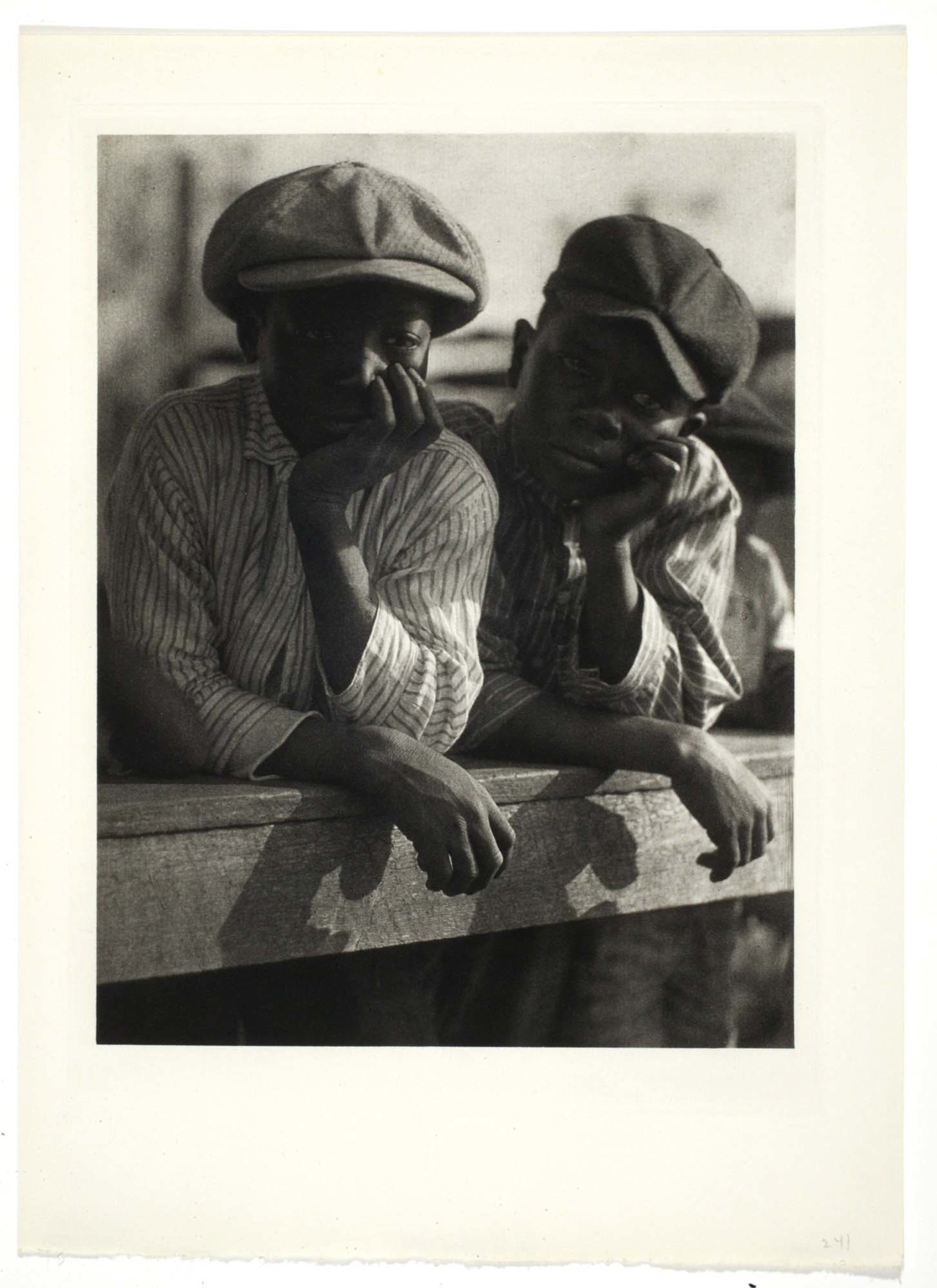 [Two boys leaning on fence] | International Center of Photography