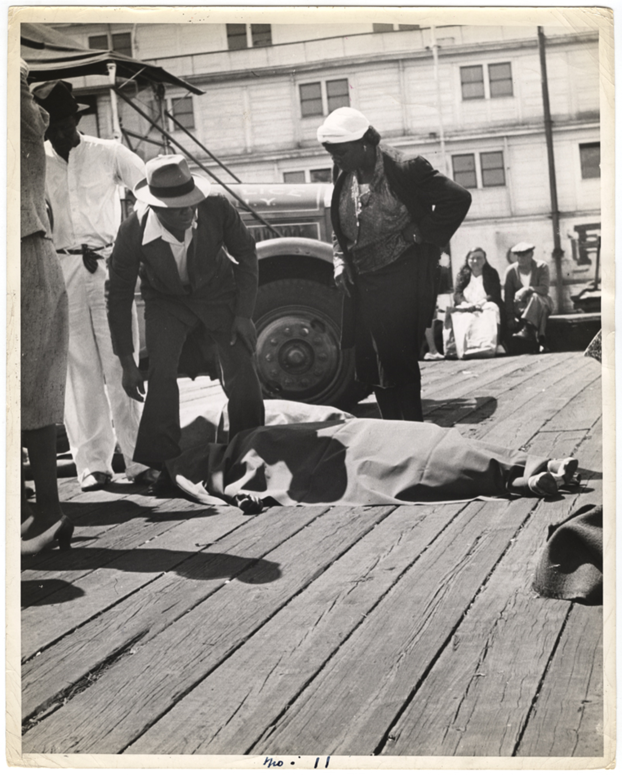 [Bystanders looking at blanket-covered body of woman trampled to death ...