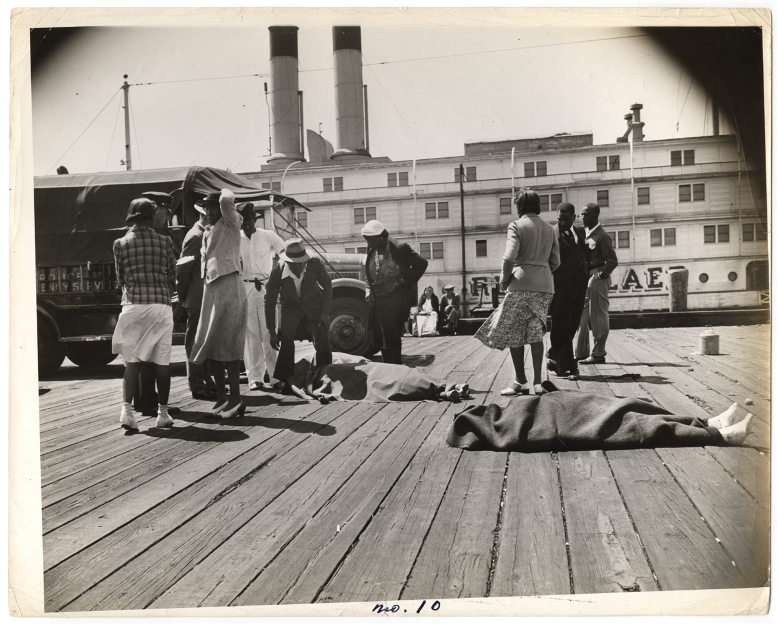 [Bystanders looking at blanket-covered body of woman trampled to death ...