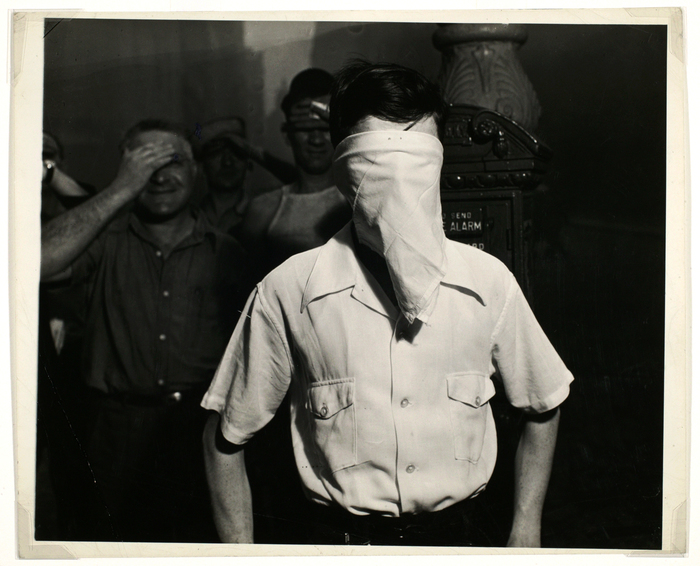Man covering face from smoke | 1International Center of Photography