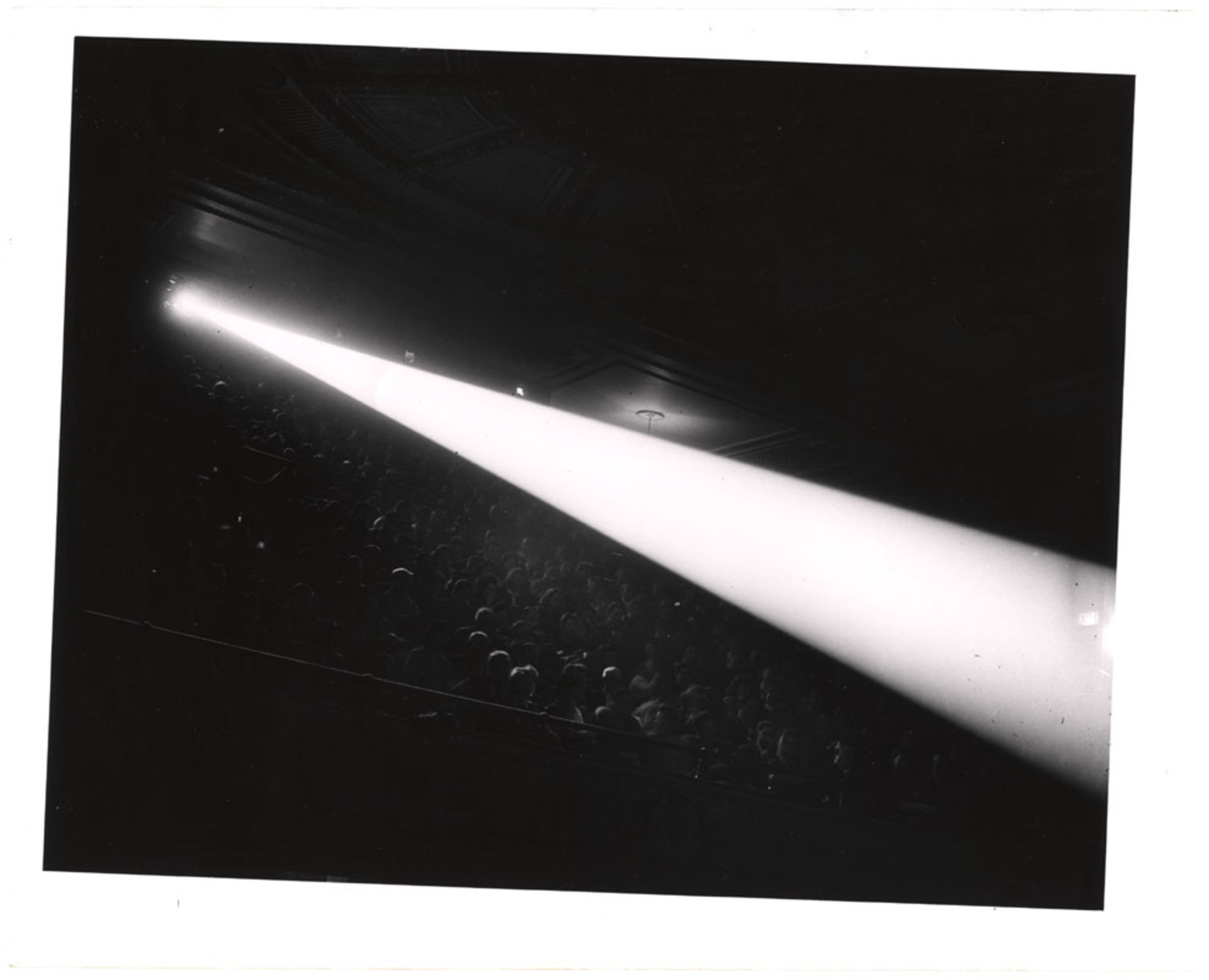 Cone of light from a movie film projector and balcony audience ...