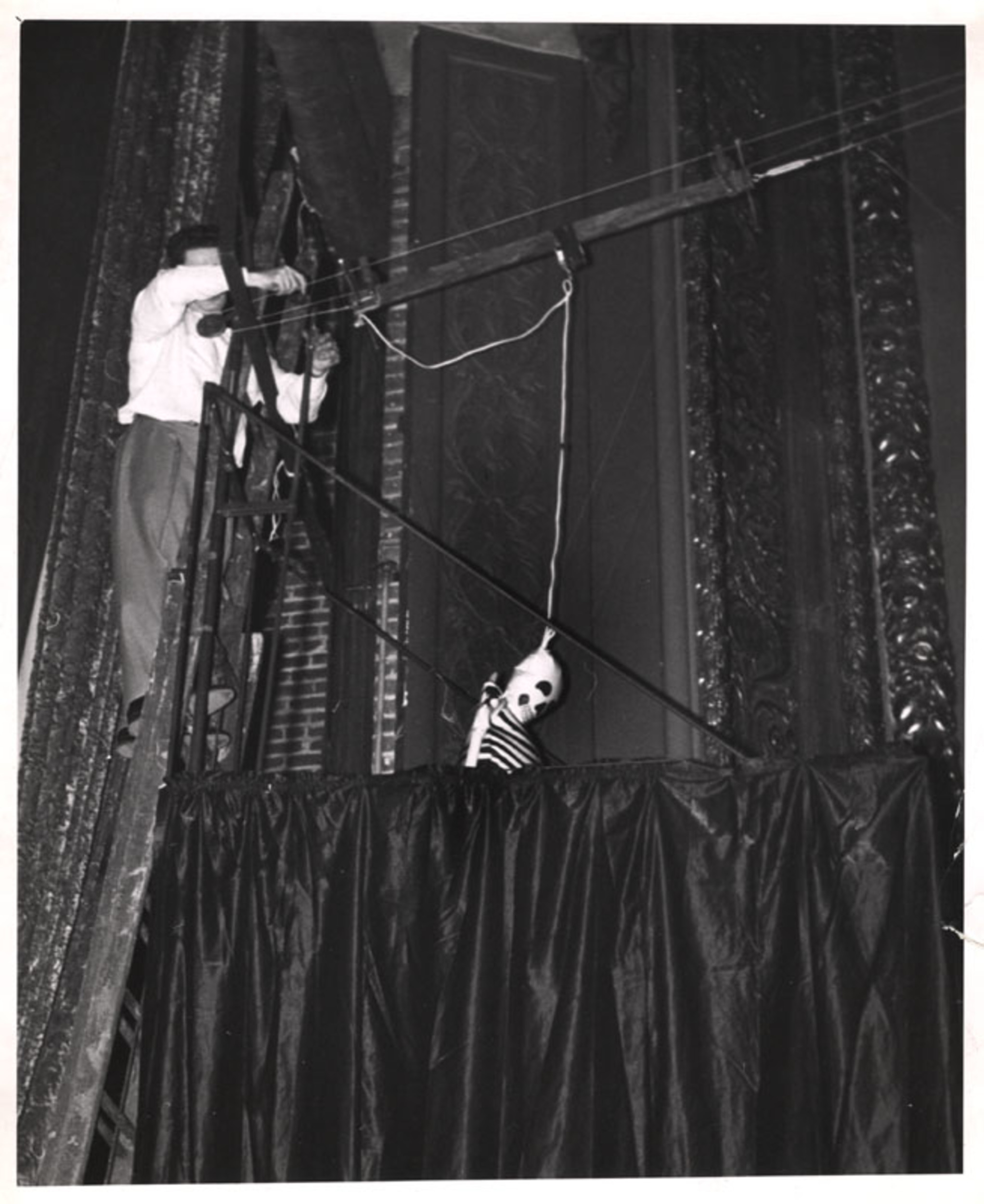 [Man hanging skeleton from movie theater ceiling for screening of ...