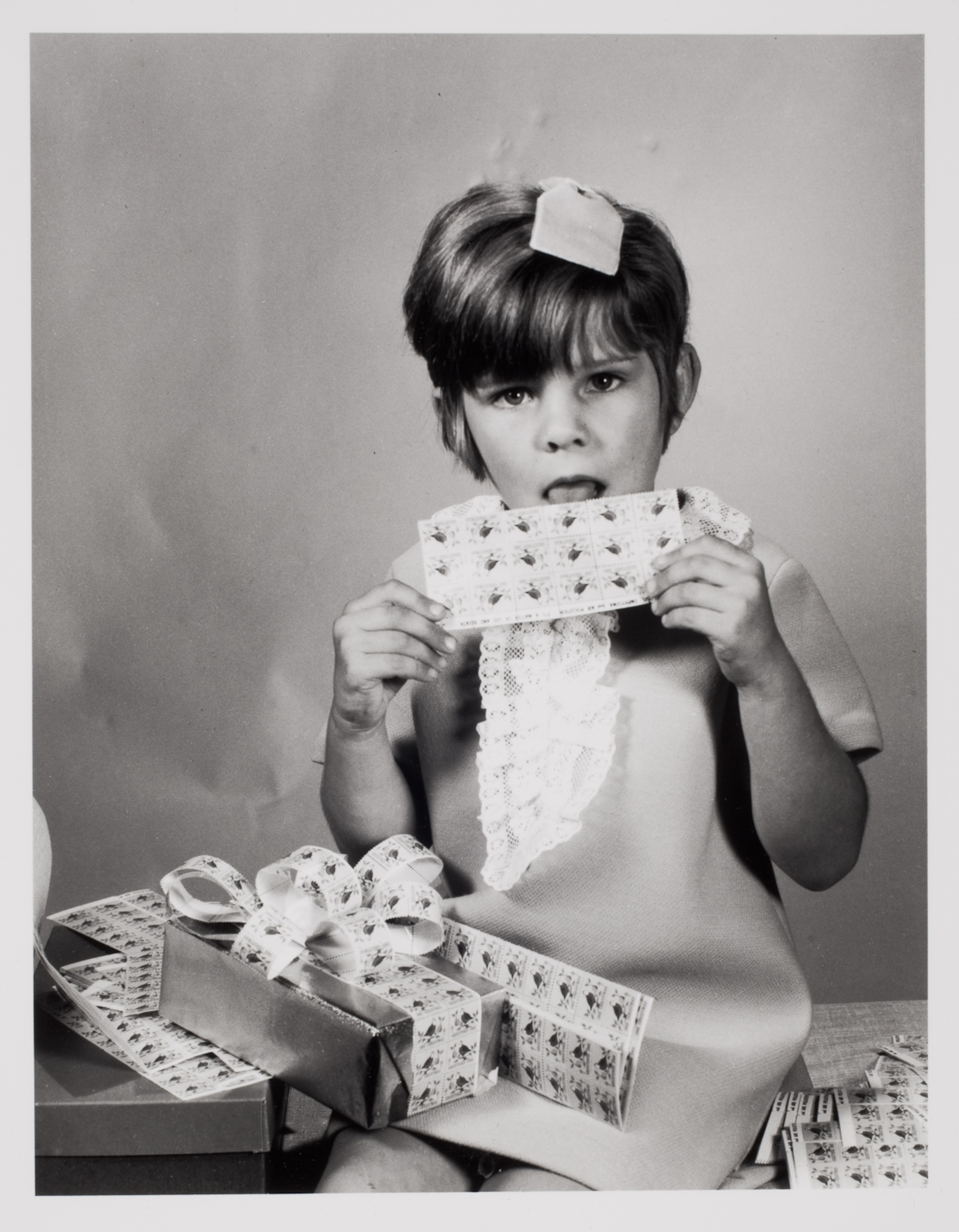 [Girl licking stamps] | International Center of Photography