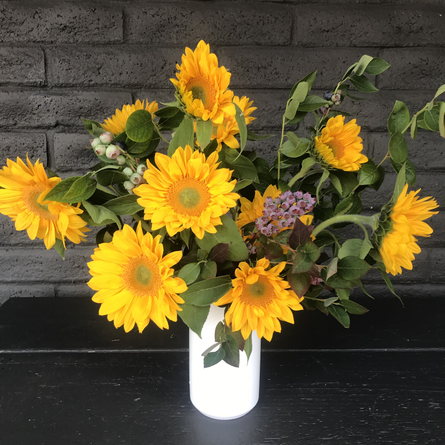 LOCAL SUNFLOWERS IN TALL WHITE VASE