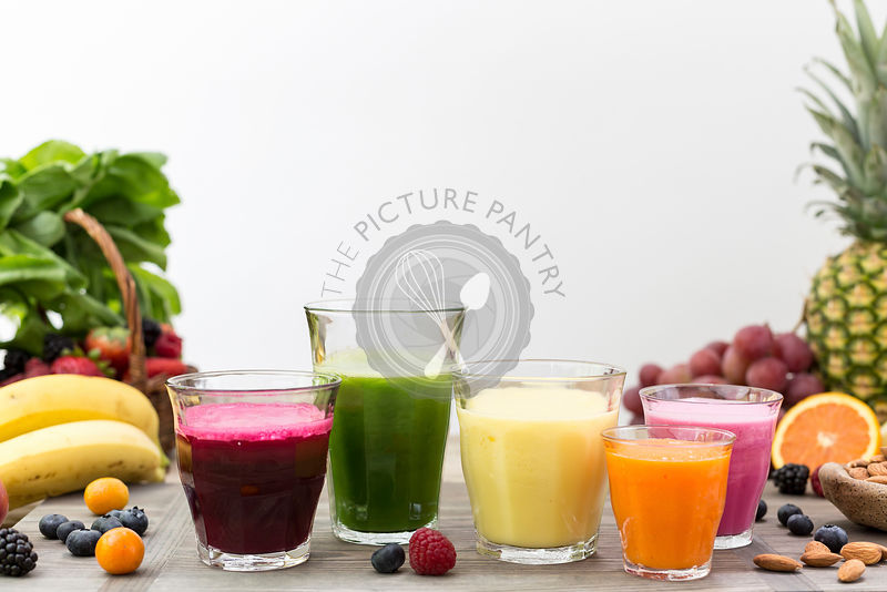 Five glasses of fresh smoothies (in all different colors) are ...